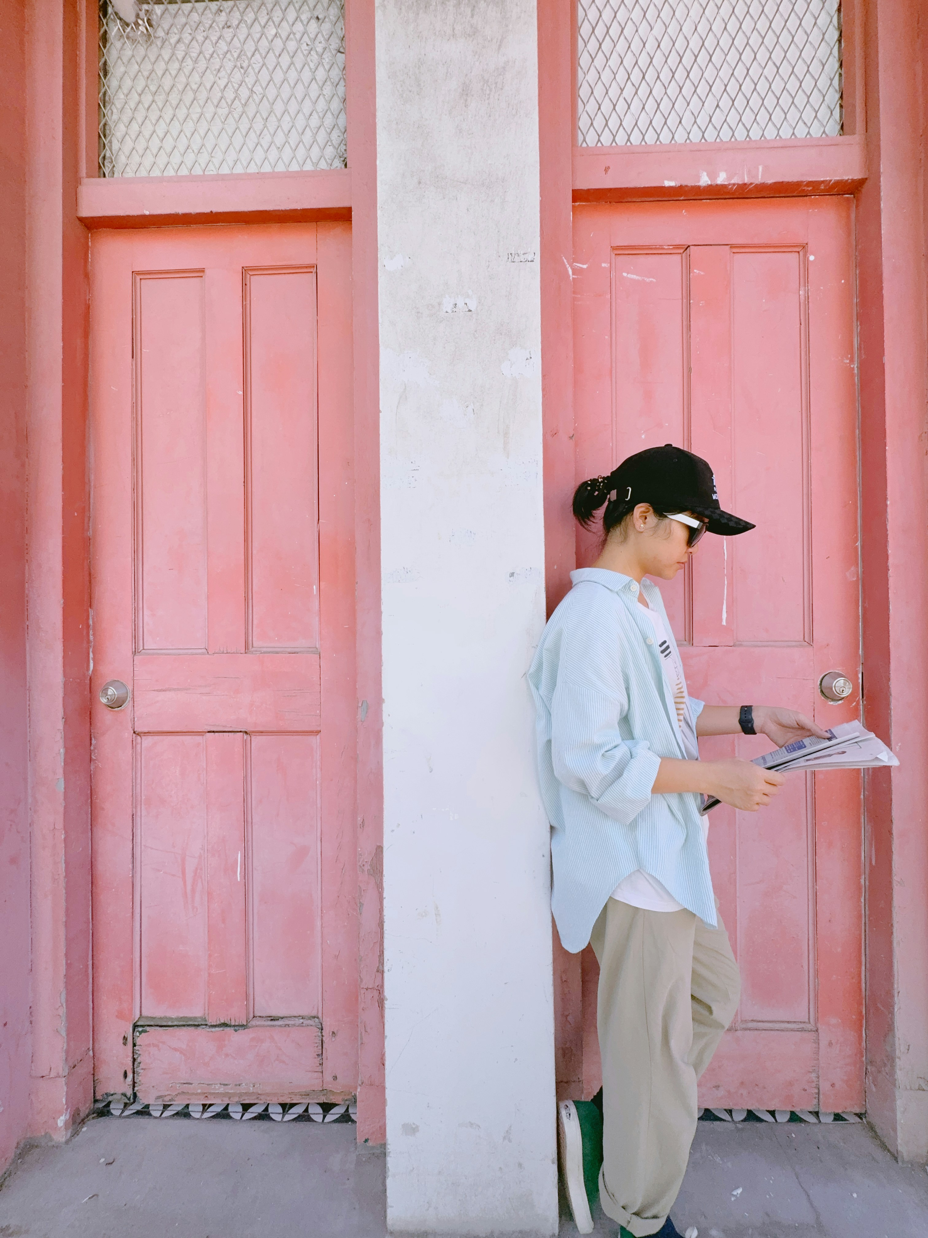 Reader in a Pink Corridor: A Quiet Moment by the Door