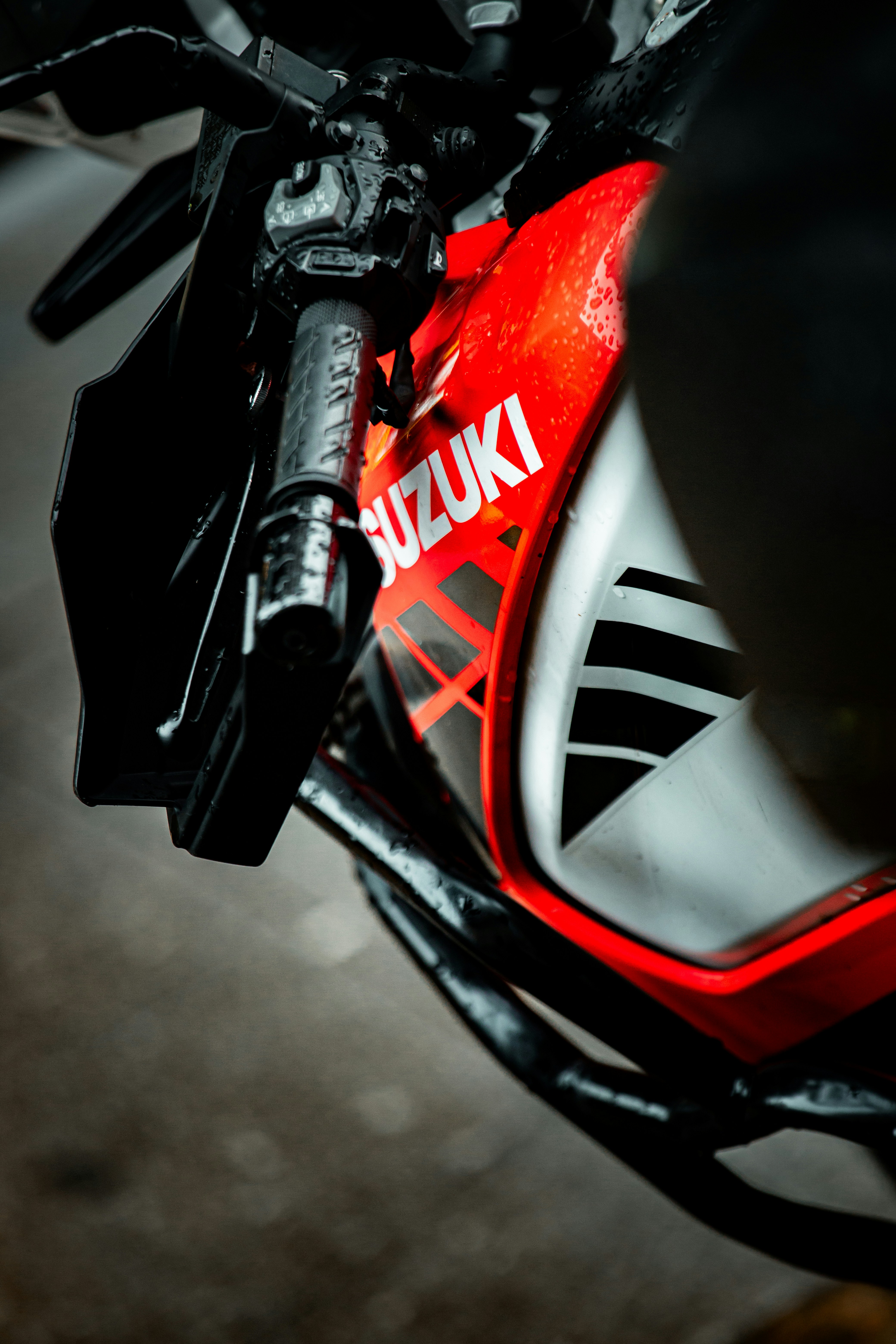 Red Power: Suzuki Moto Close-Up on a Rain-Slick Frame