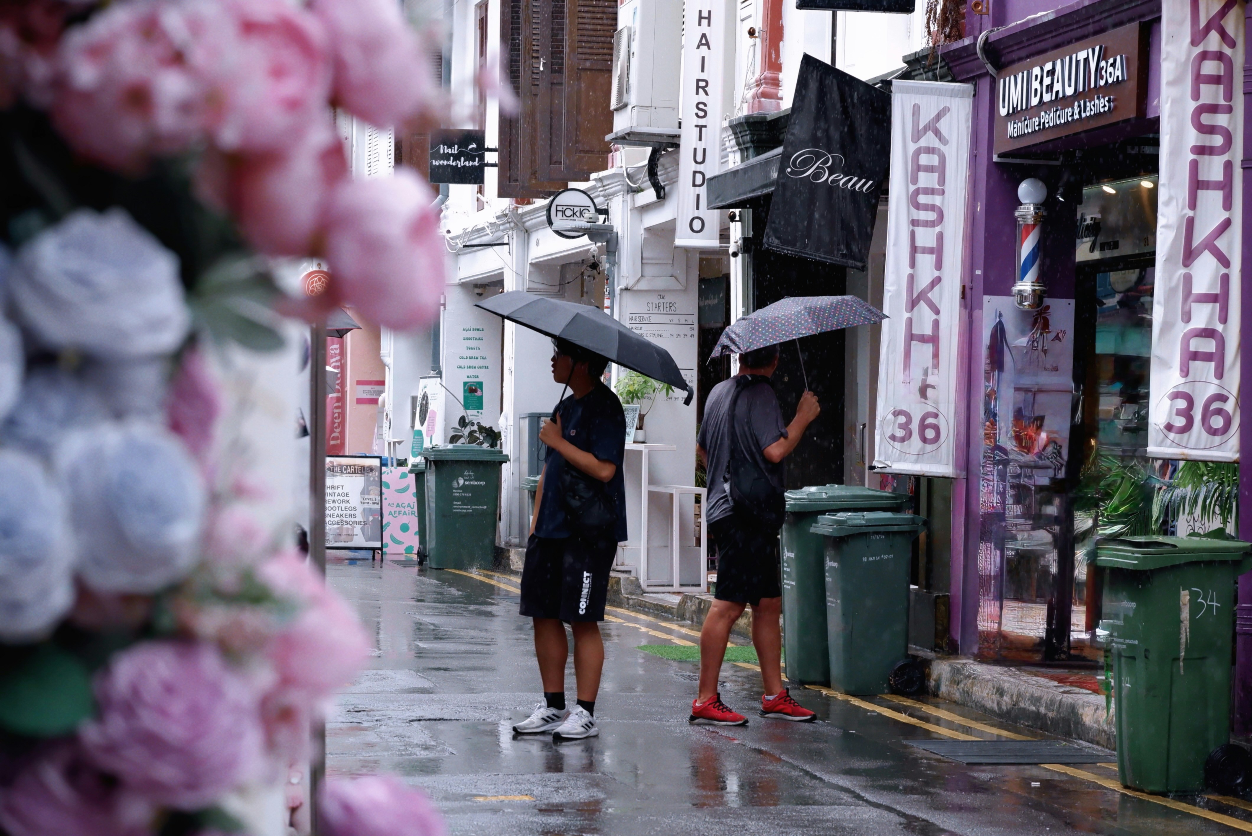 Urban Rain and Umbrellas: A Quiet Moment on a Shimmering Street