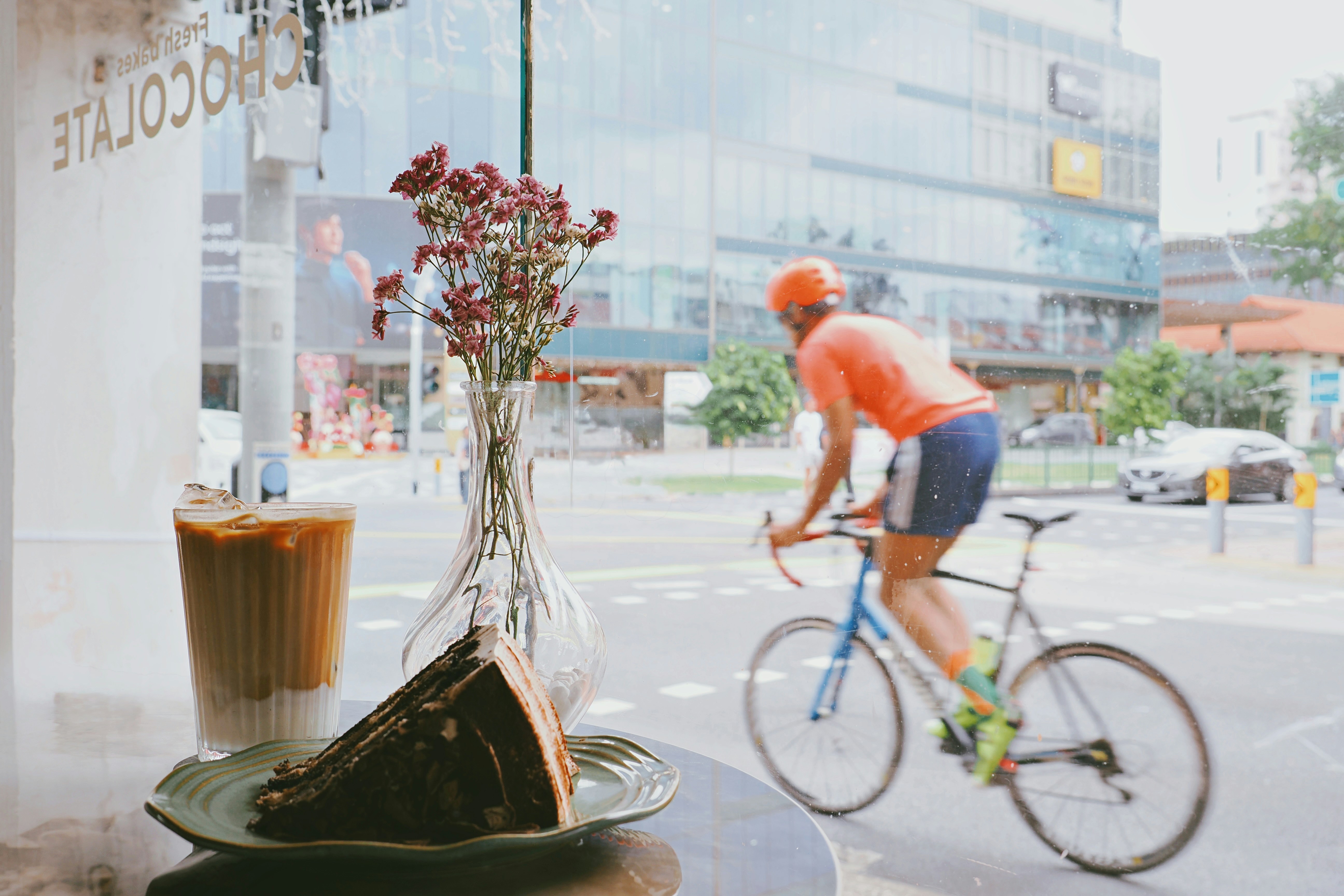Street Scene through a Café Window: Whiskey Light and a Blurred Cyclist