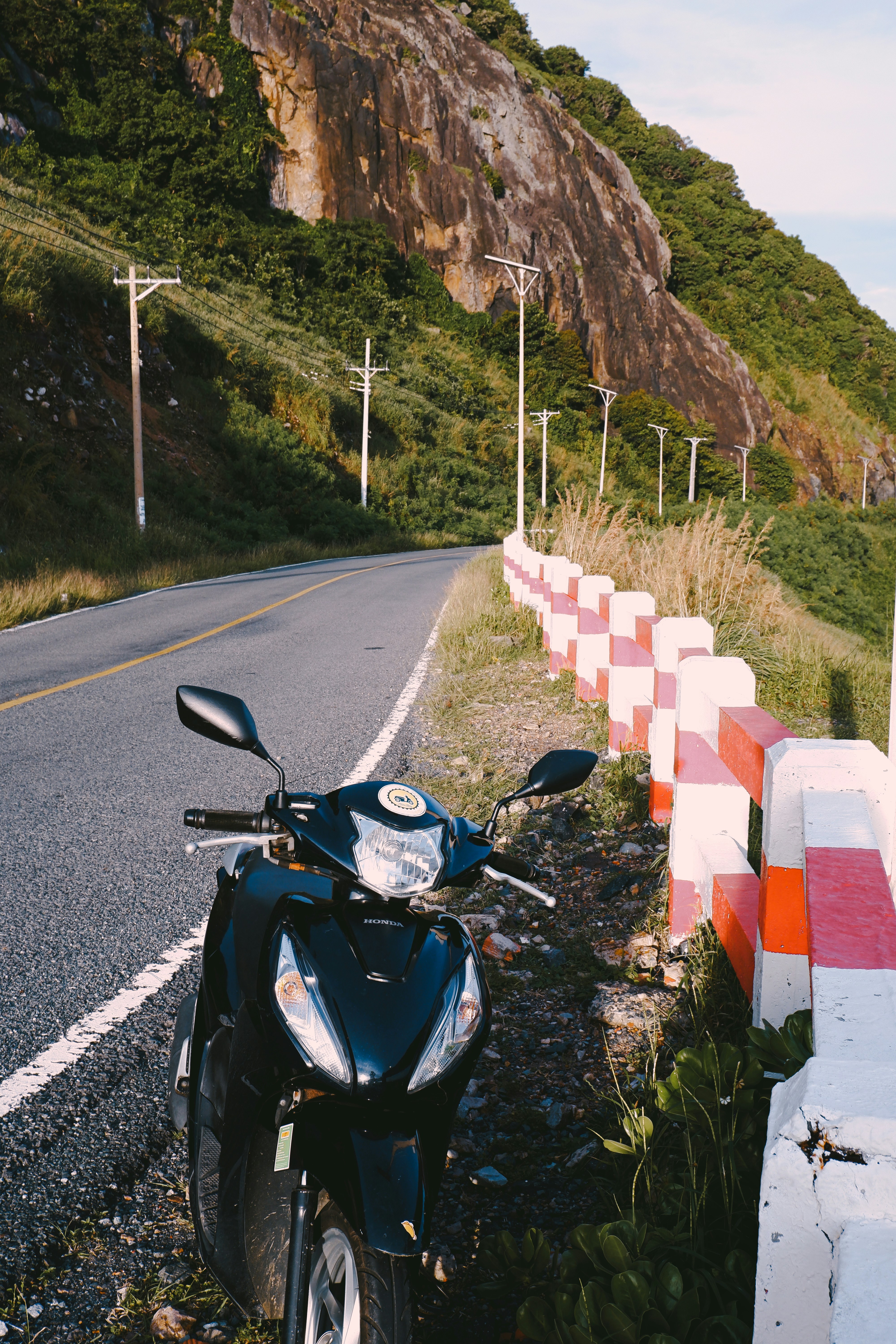 Ride Along the Cliff Road: A Black Motorcycle by the Guardrail