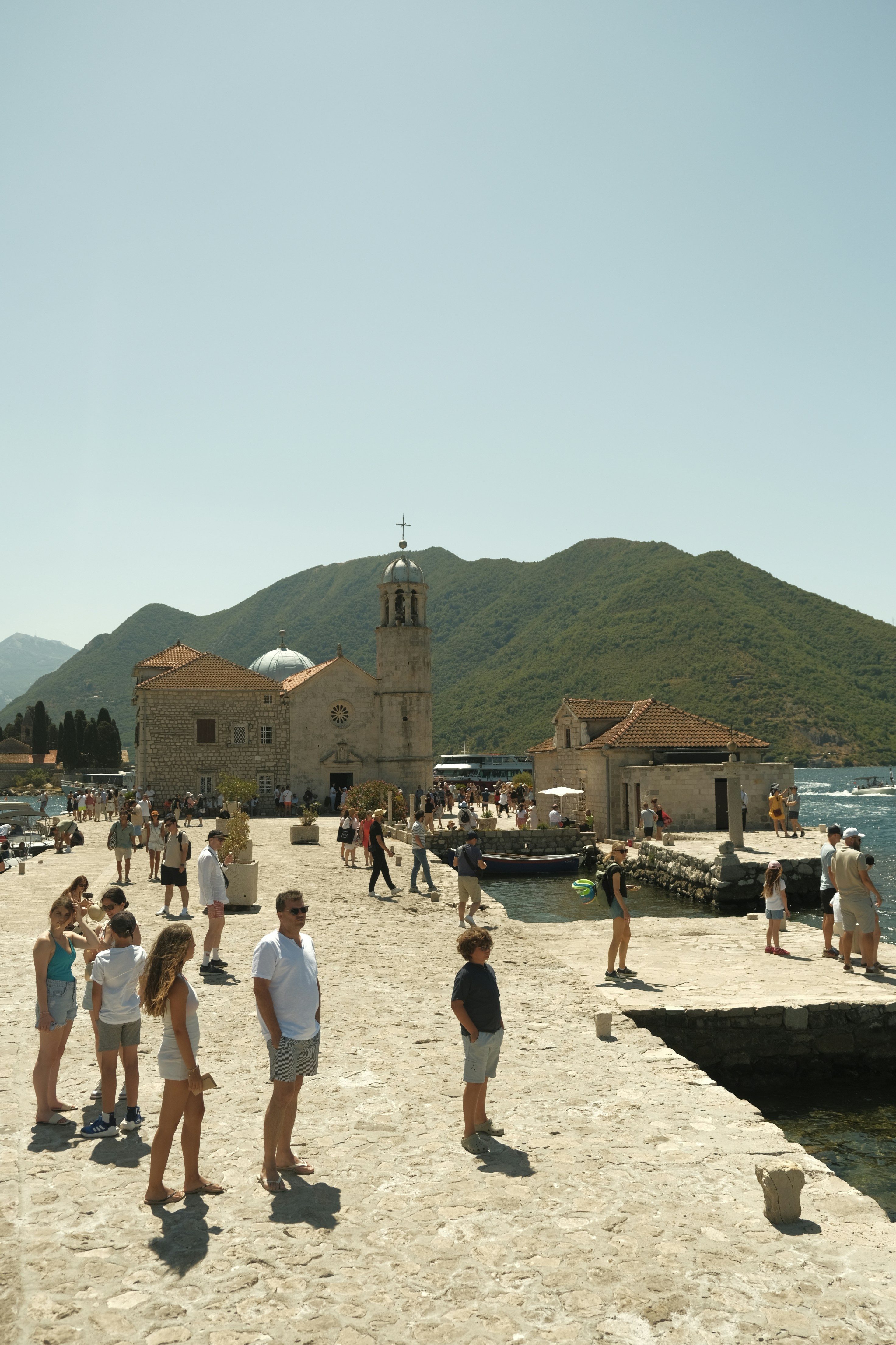 Harbor of Time: Tourists and Historic Stone Structures by the Adriatic
