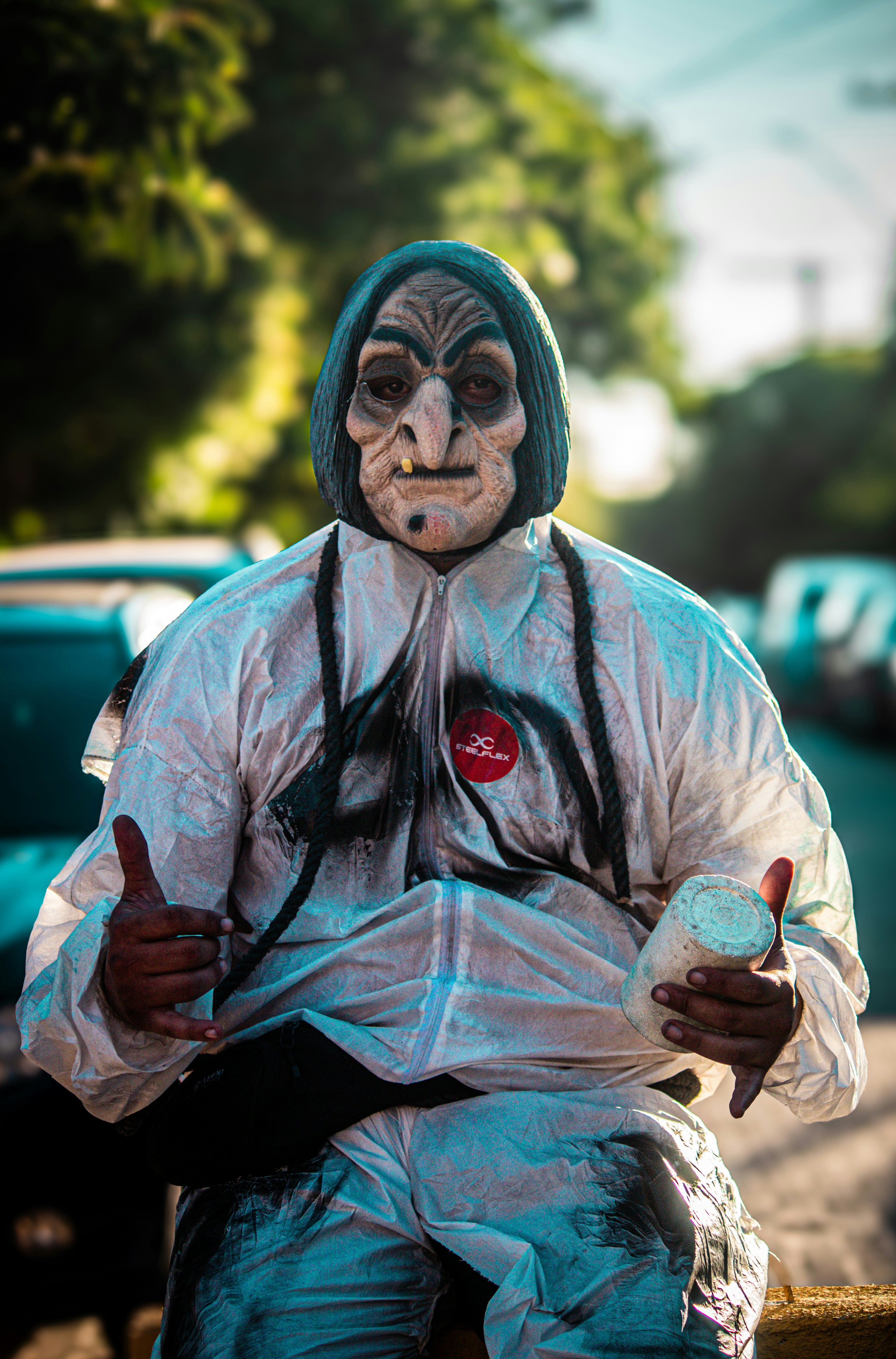 Mask of Mischief: Street Performer in a Silver Suit Outdoors