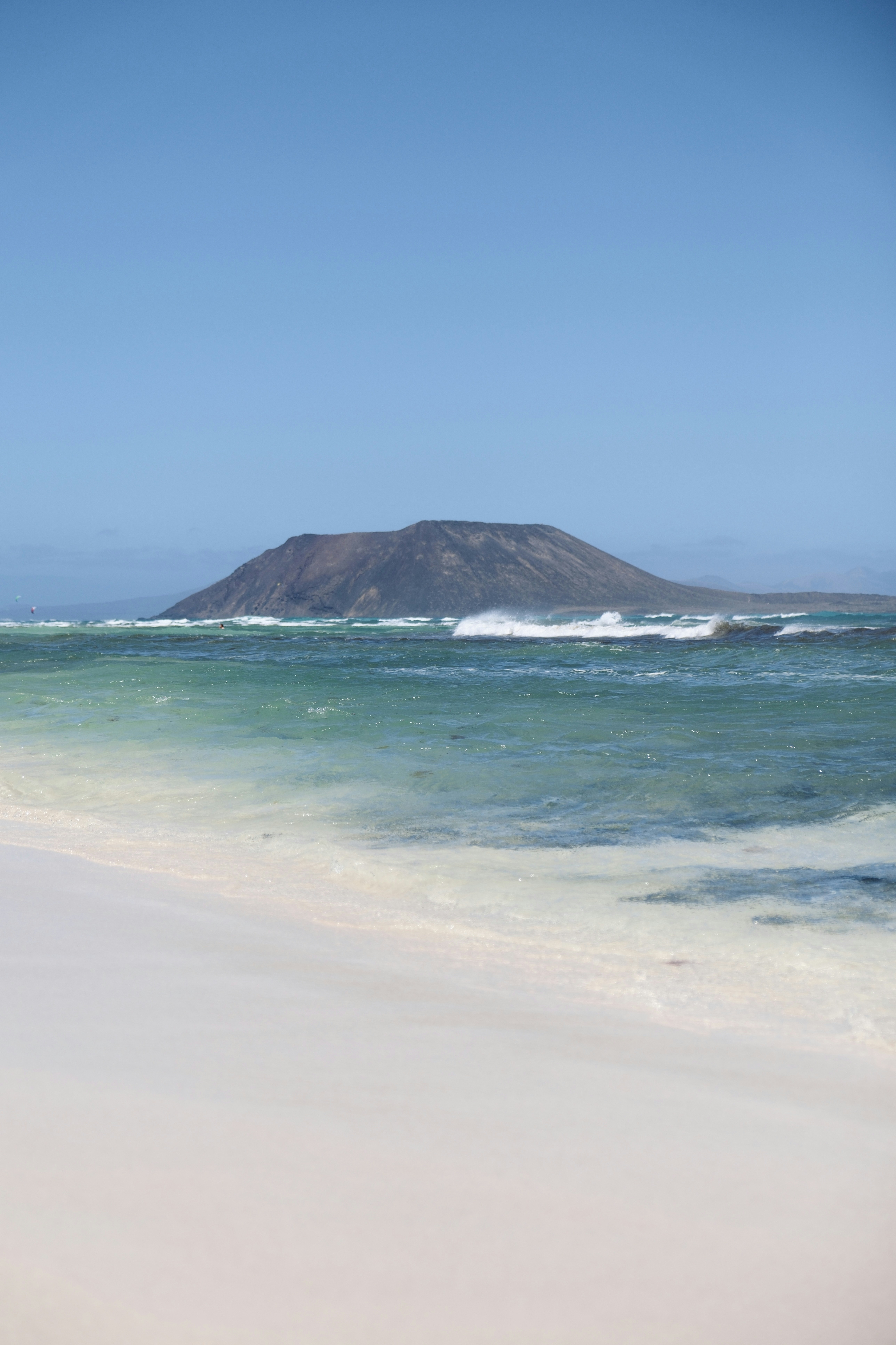 Isolated Island Ridge on Quiet Turquoise Waves