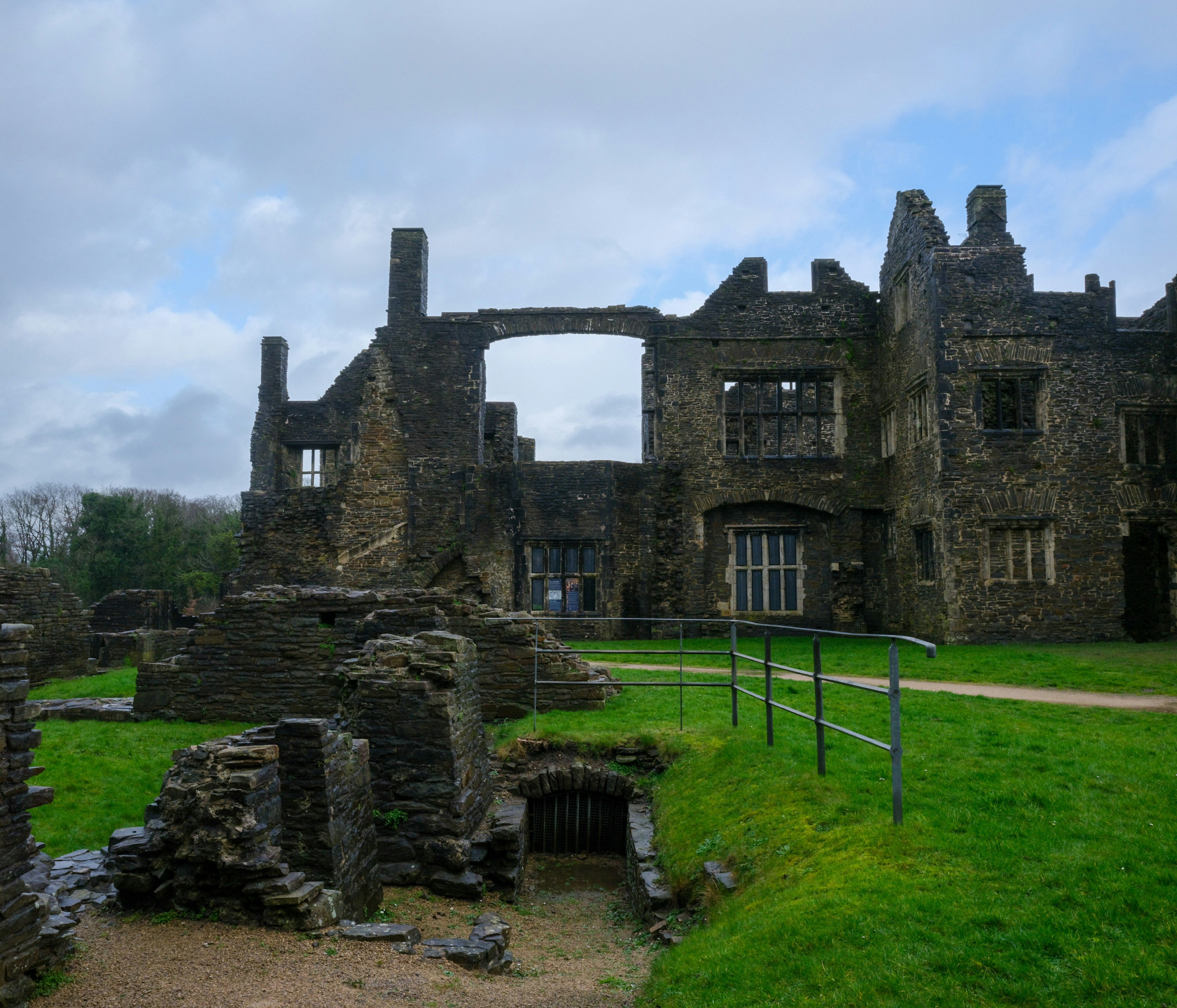 Stone ruins of a historic building under a cloudy sky