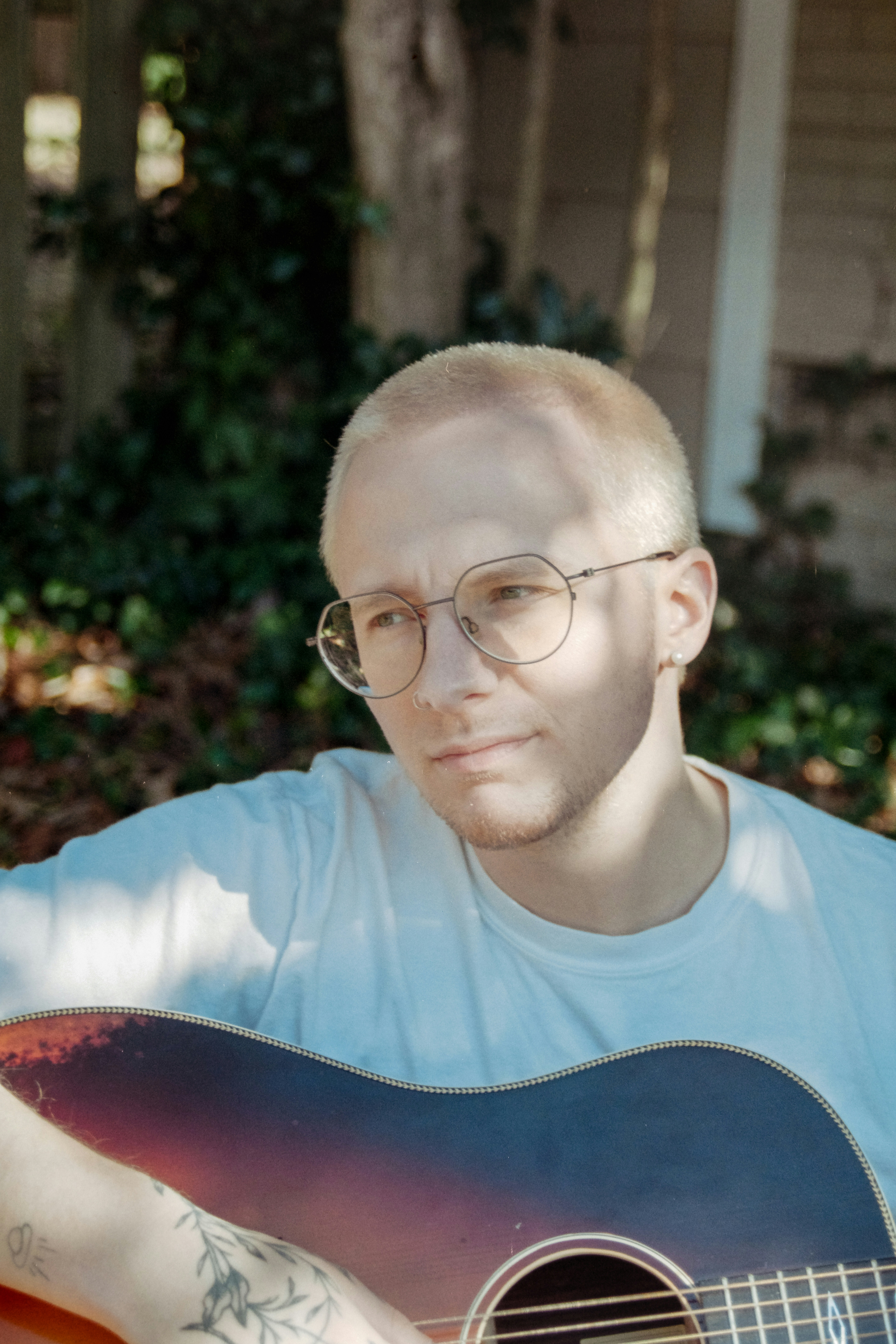 Sunlit Strums: Silent Focus on a Guitarist in the Garden