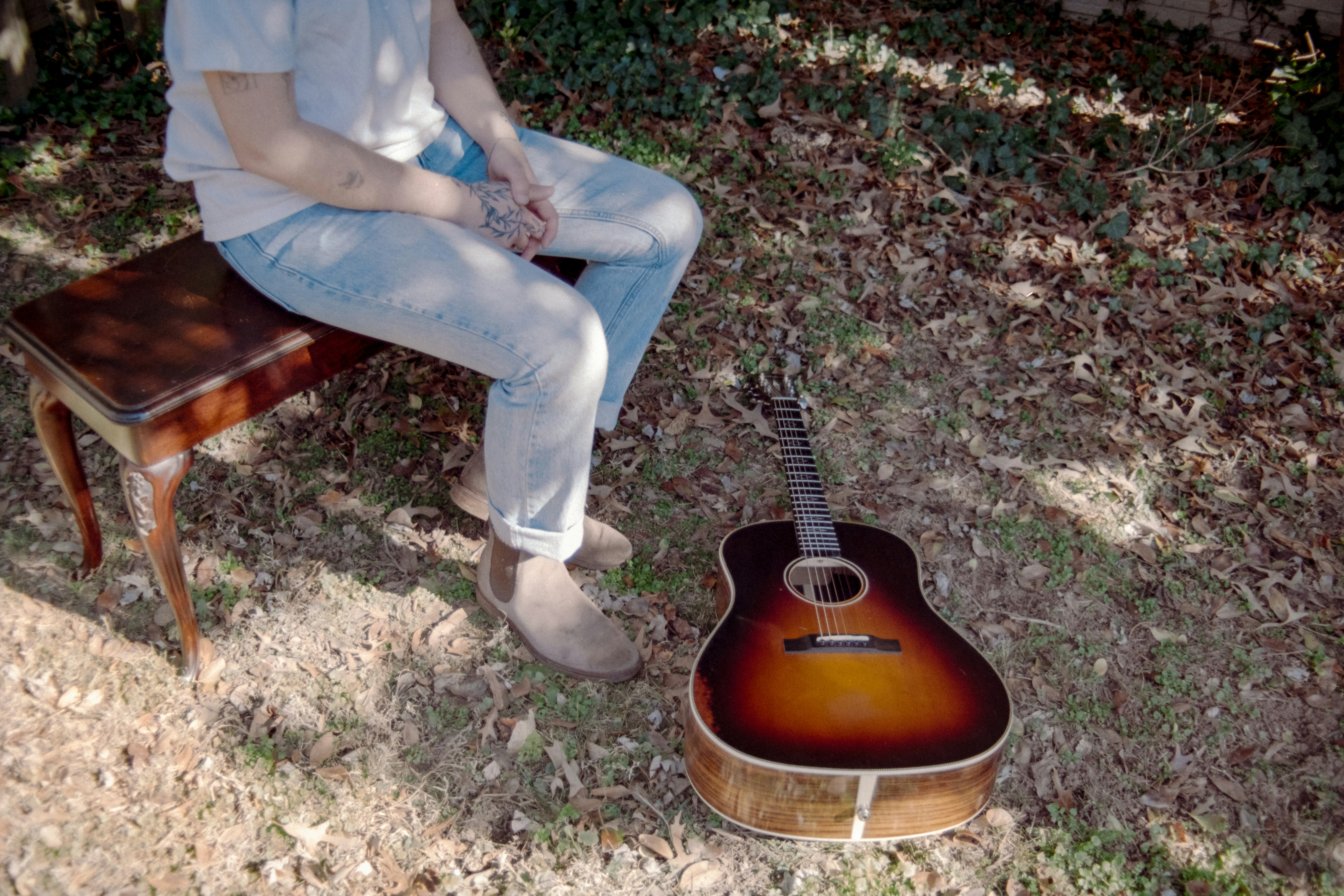 Sunlit Strings: A Guitar Resting beside a Quiet Porch Sit