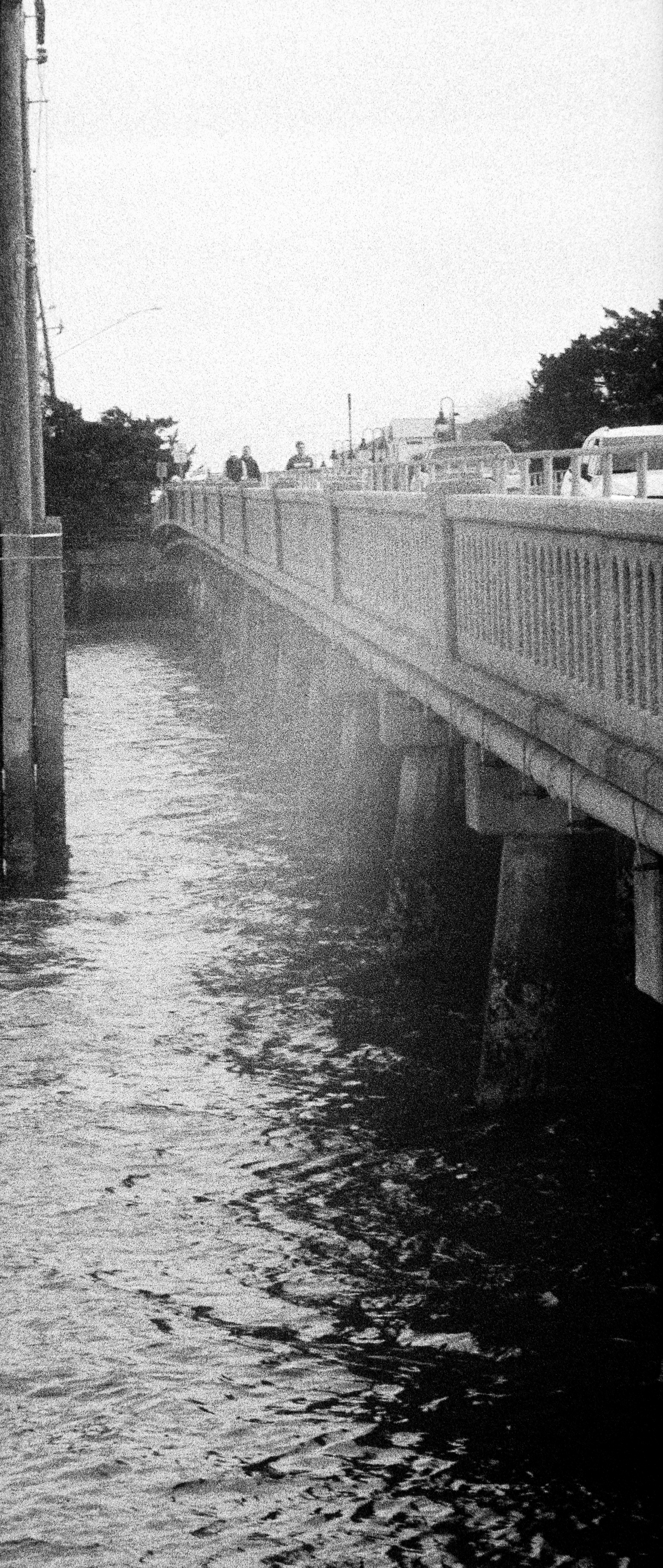 Bridge over Quiet Tides: A Grainy Walkway into the Distant Light