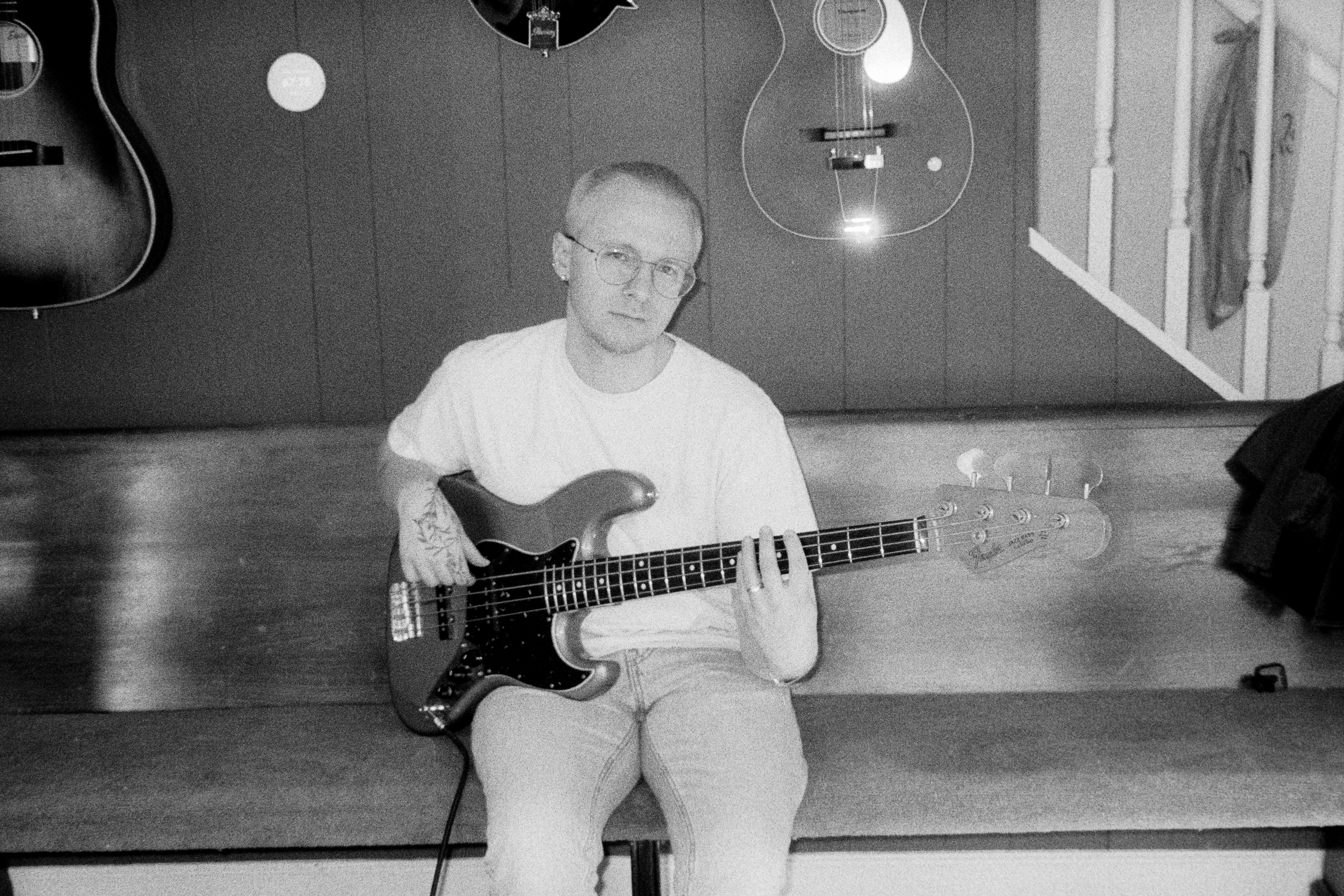 Basslines in a Quiet Studio: A Musician's Moment with a Guitar