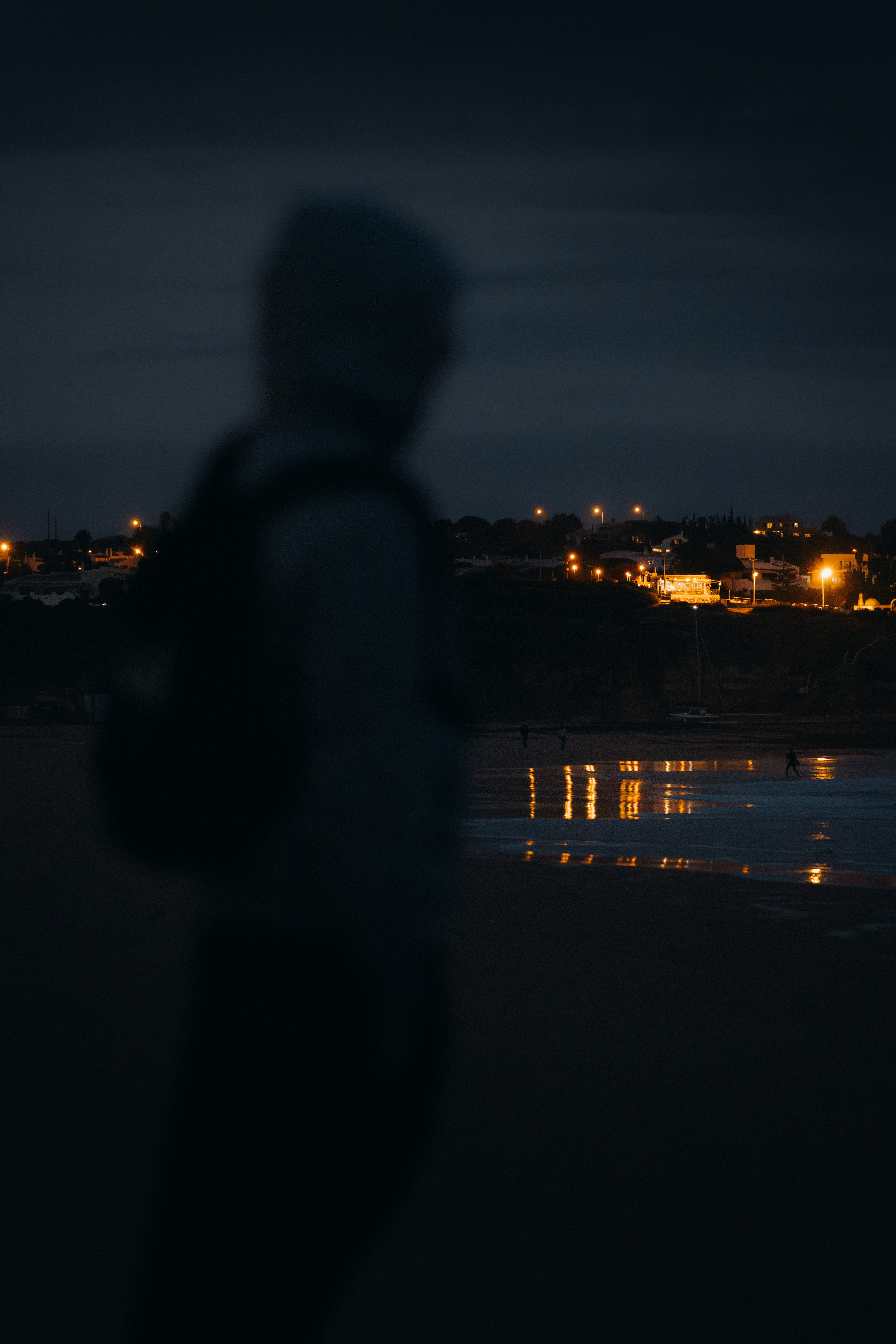 Midnight Shoreline: A Quiet Figure Overlooked by Neon Waves