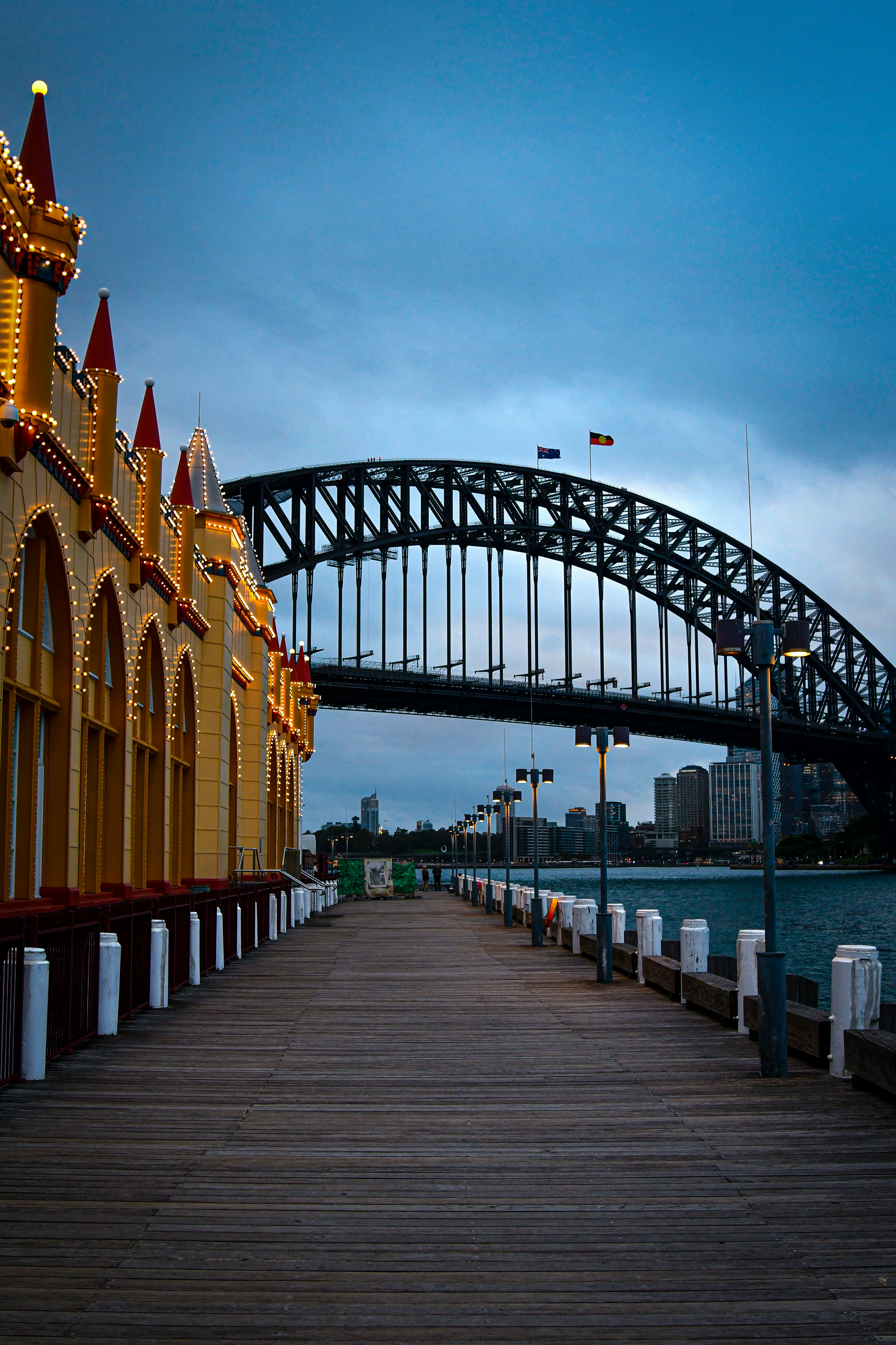 Harbor Walk to the Arch: Sydney-like Skyline Under Evening Promise