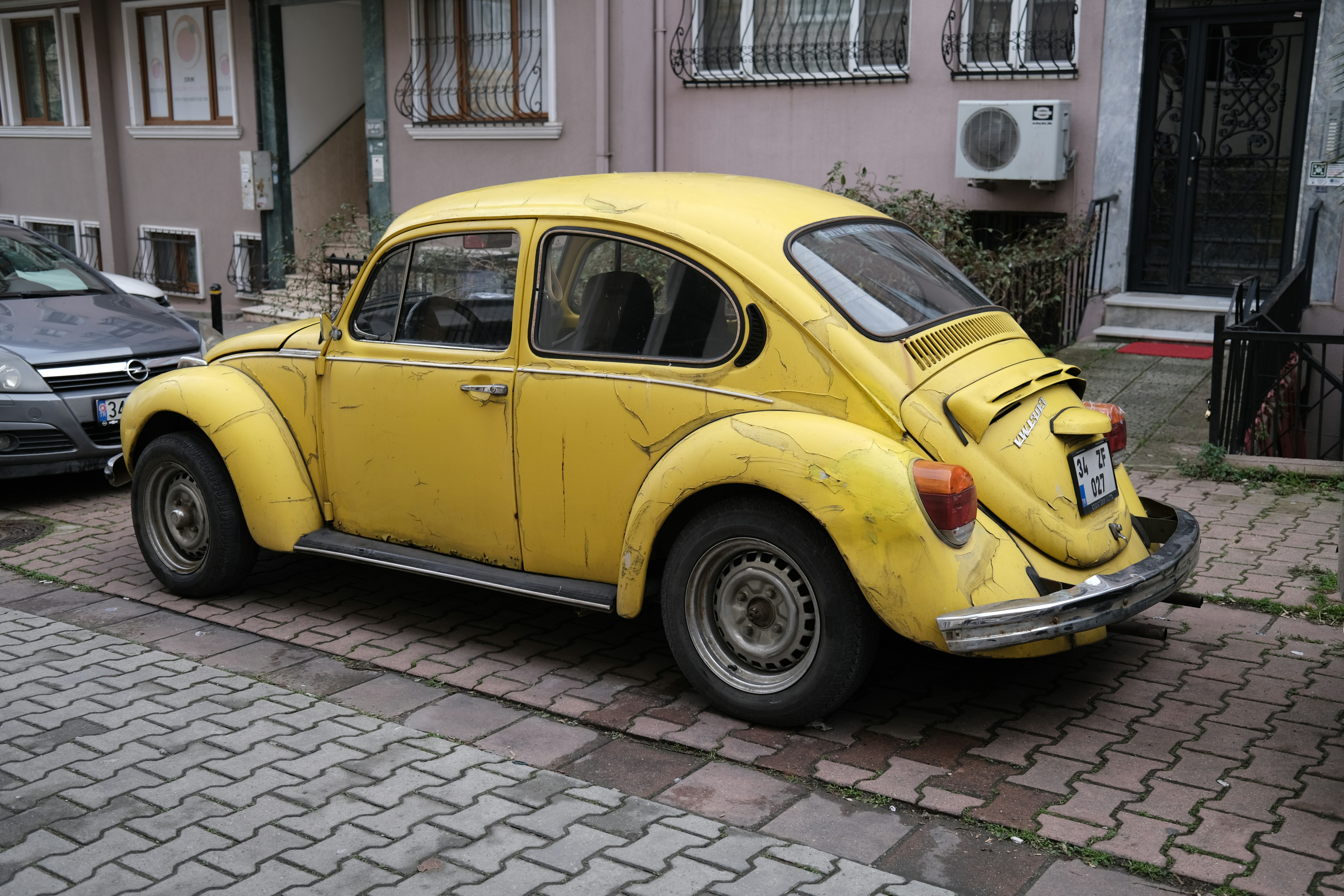 Weathered Yellow Beetle Resting on a Cobbled Street