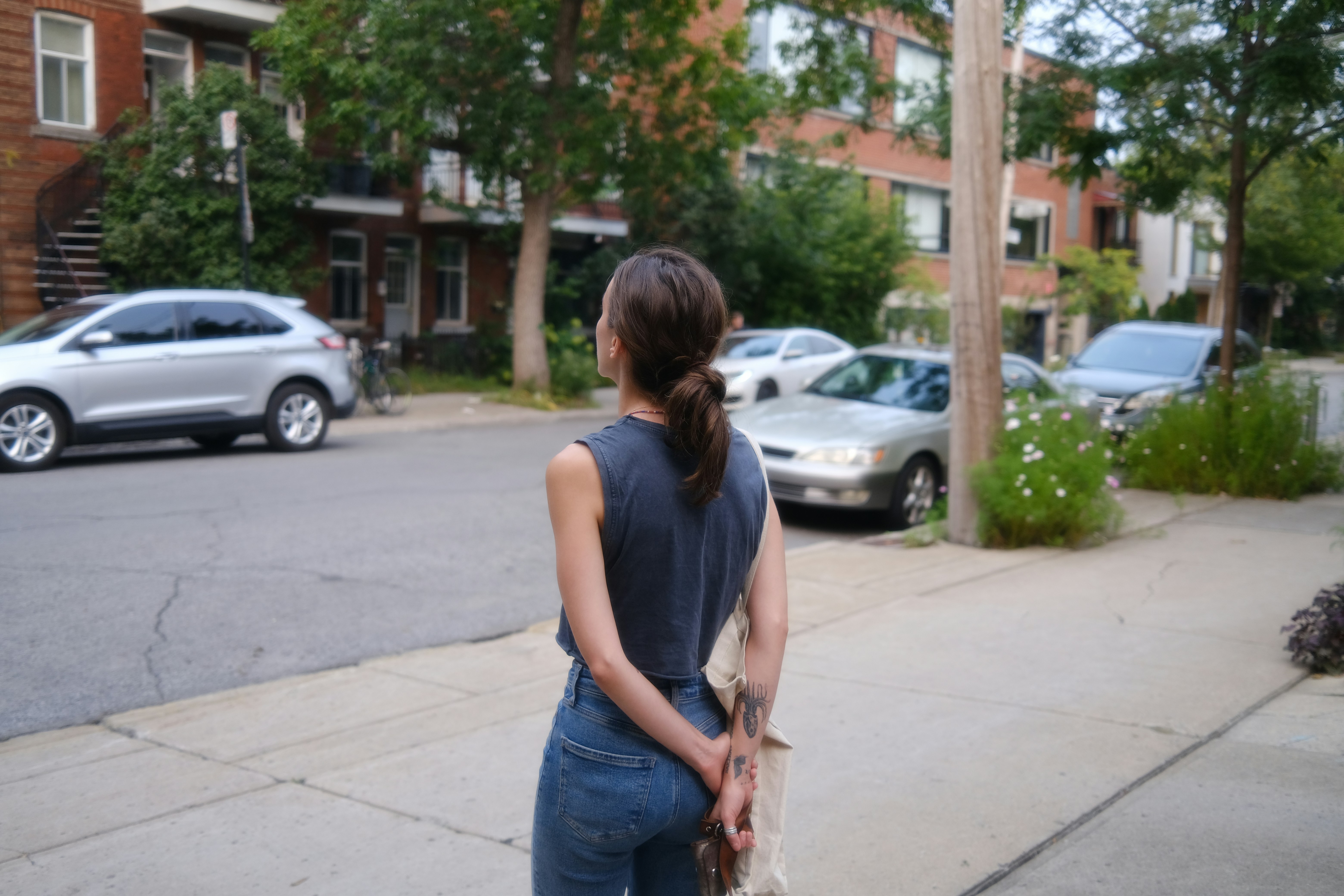 Backyard Portrait: The Woman in Jeans Walks Away Down a Quiet Street
