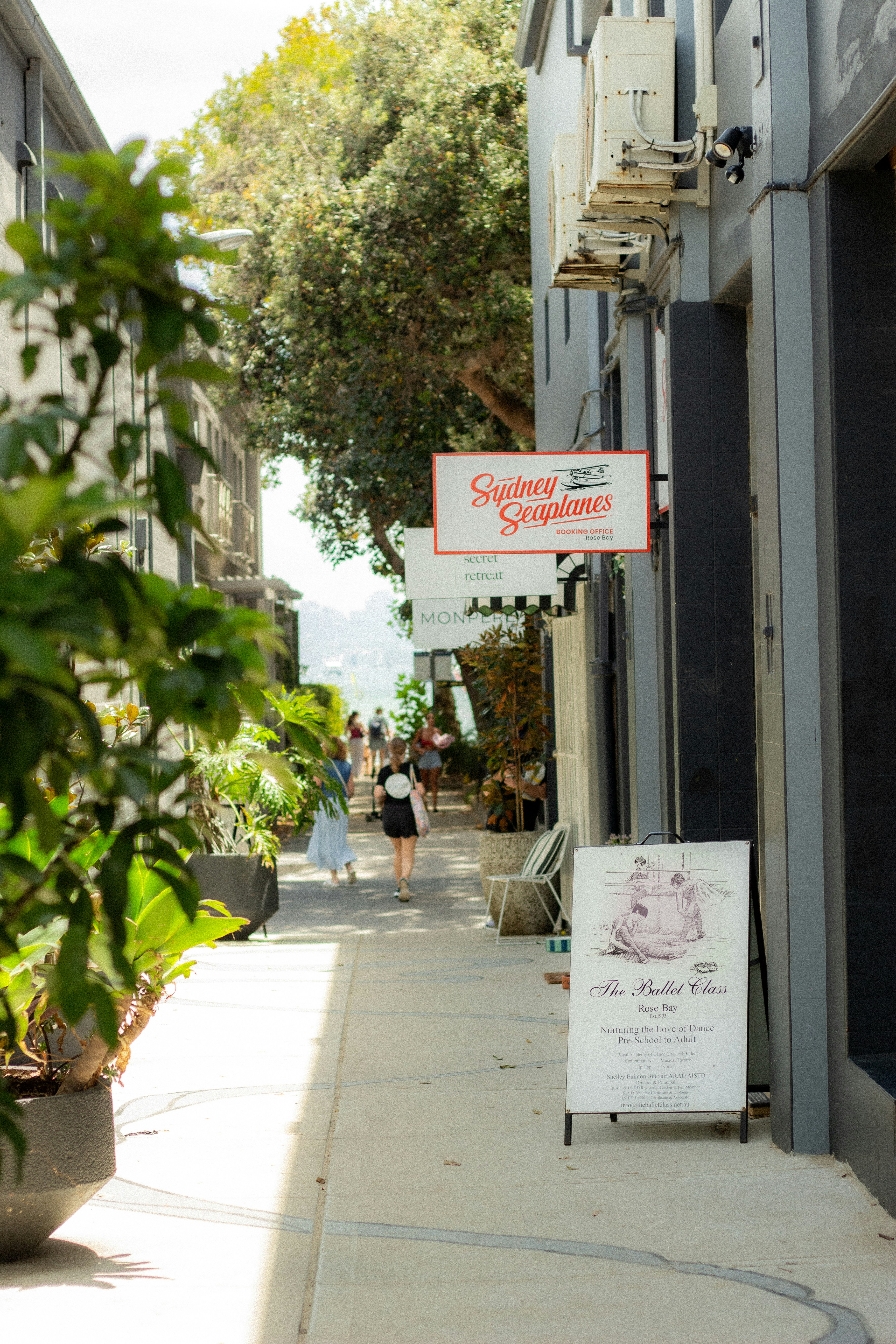 Sunlit Street Signage and Quiet Walkway