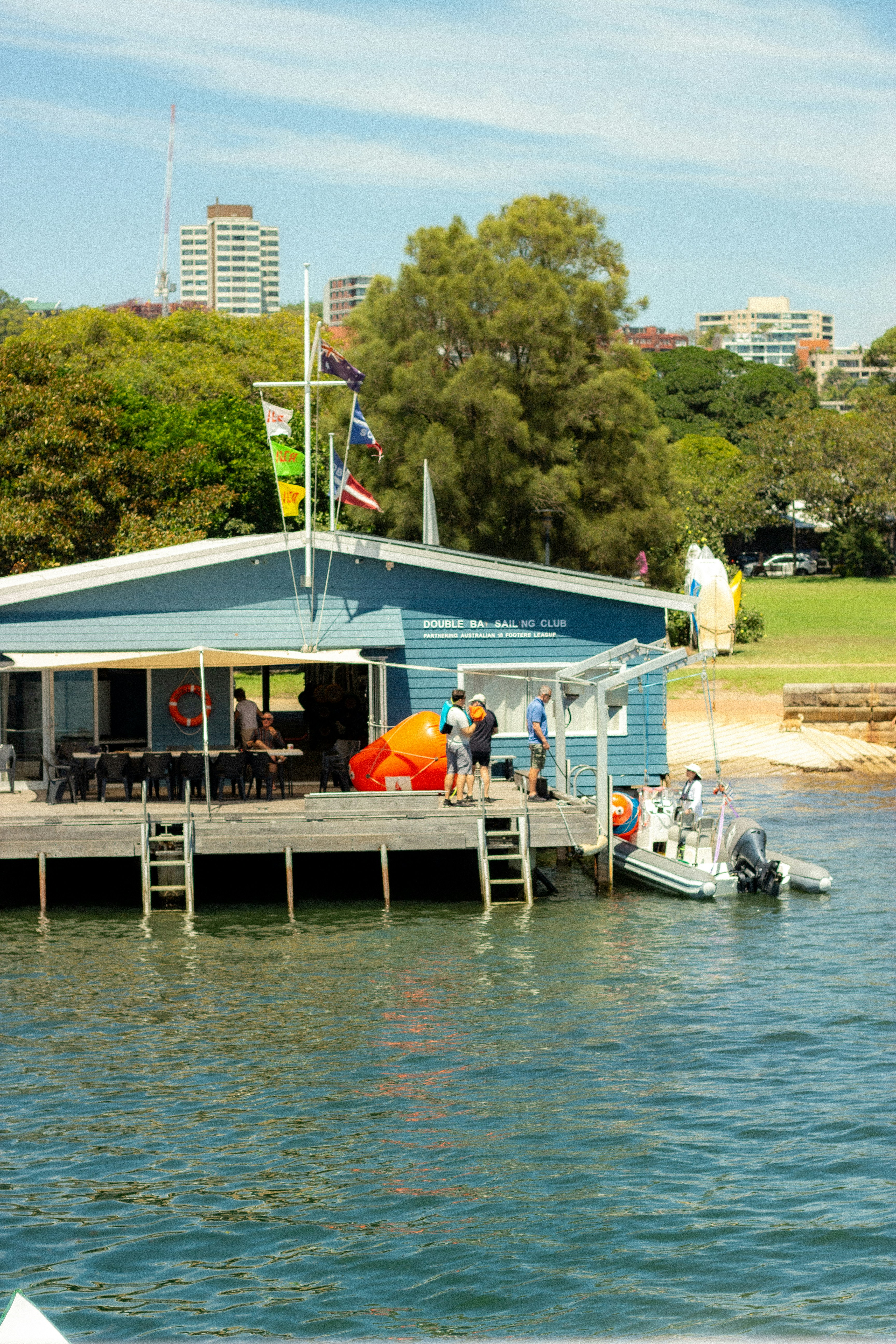 Harbor House: People at a Blue Waterfront Boathouse