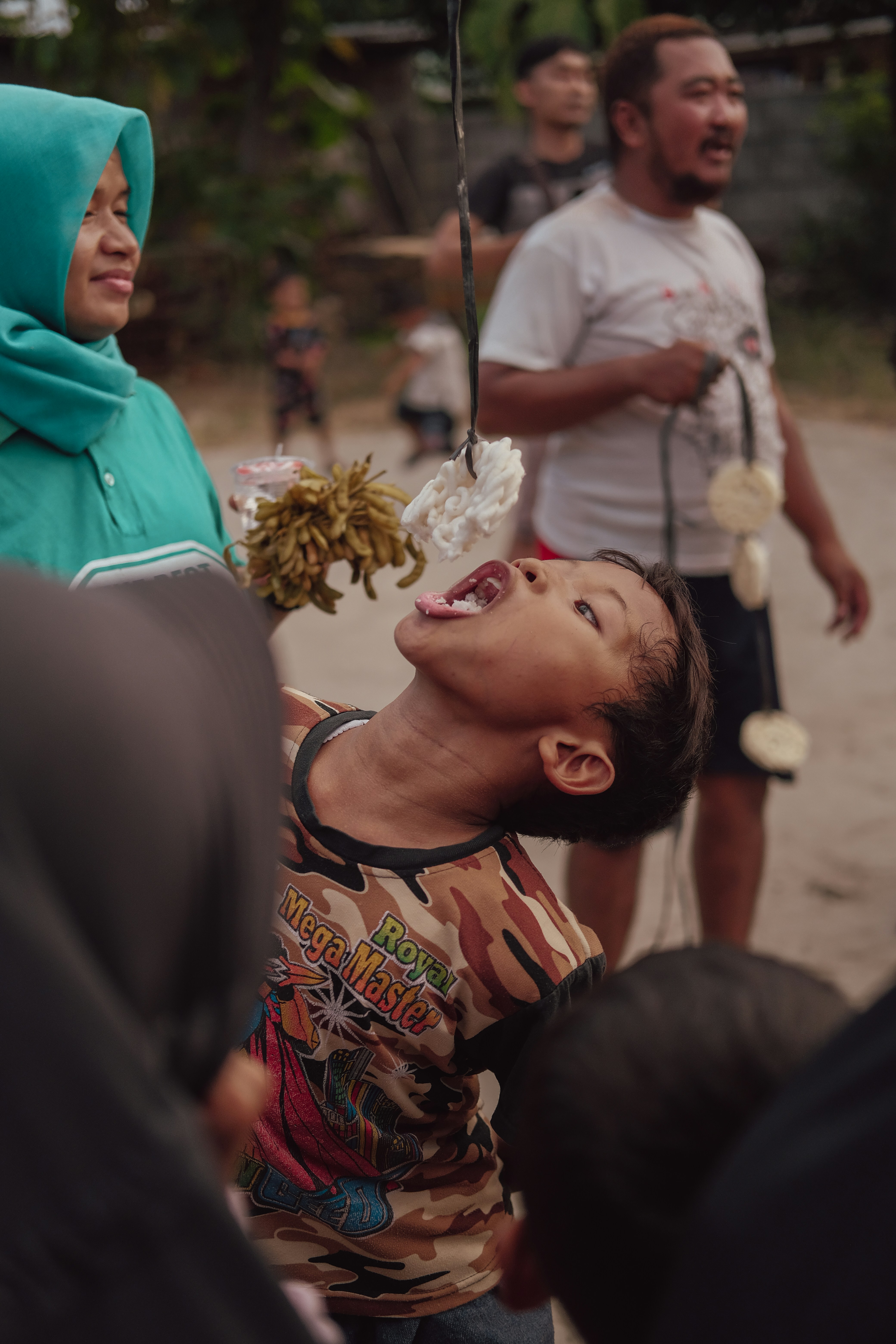 The Gulp of Give-and-Take: A Boy’s Feisty Reach for a Hanging Treat