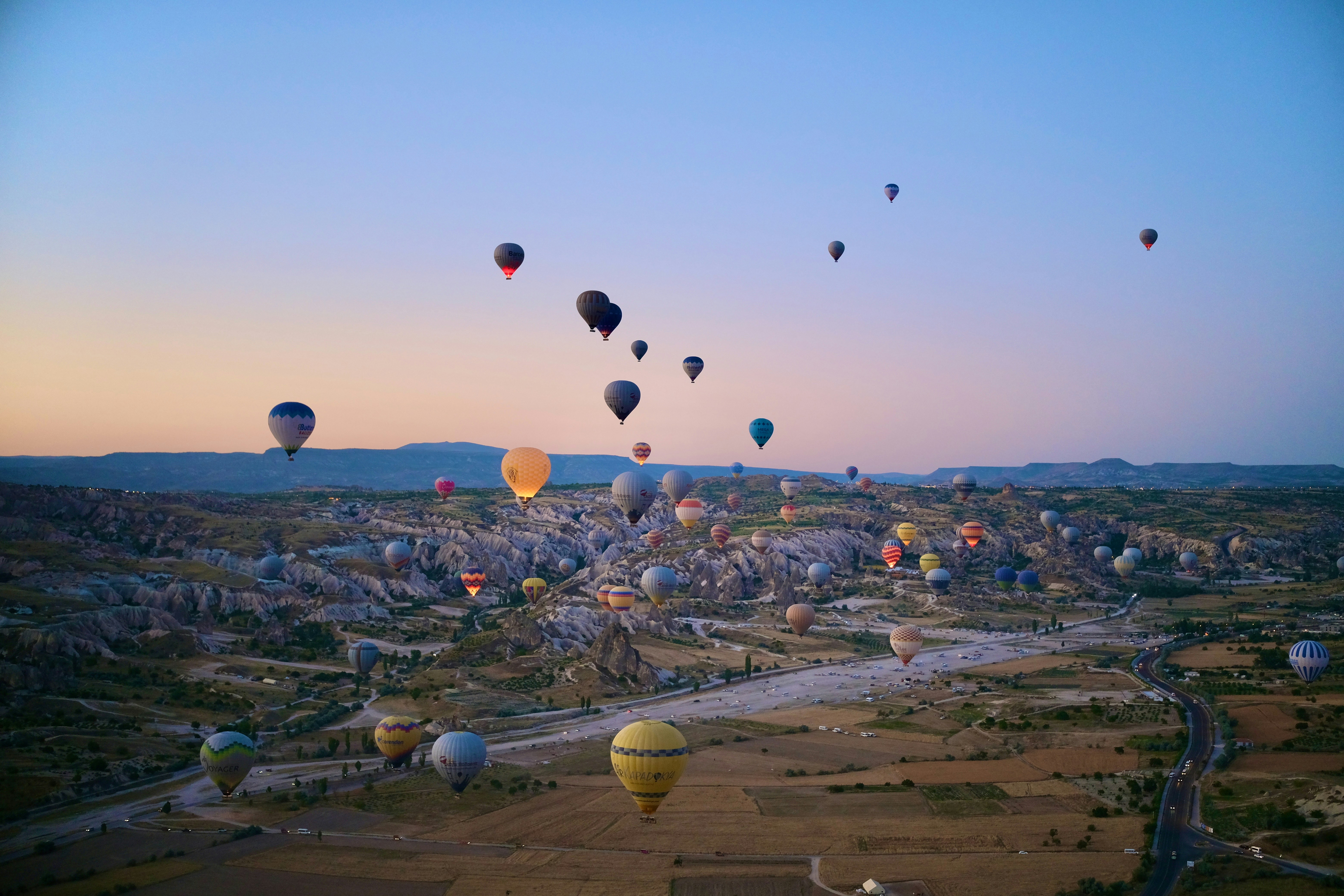 Skyward Parade: A Field of Balloons Over Rolling Dales