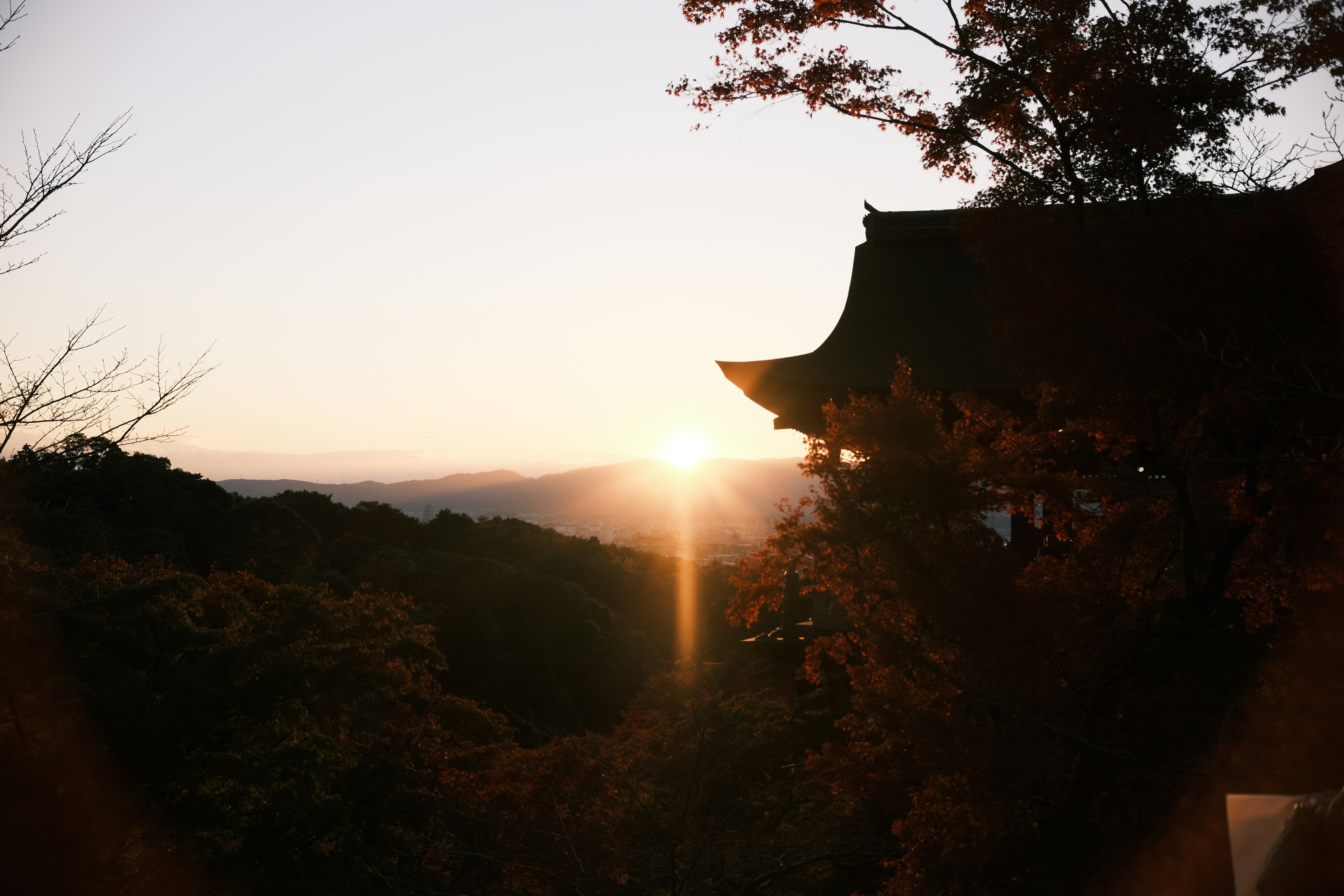 Sunset over rolling hills with traditional roof