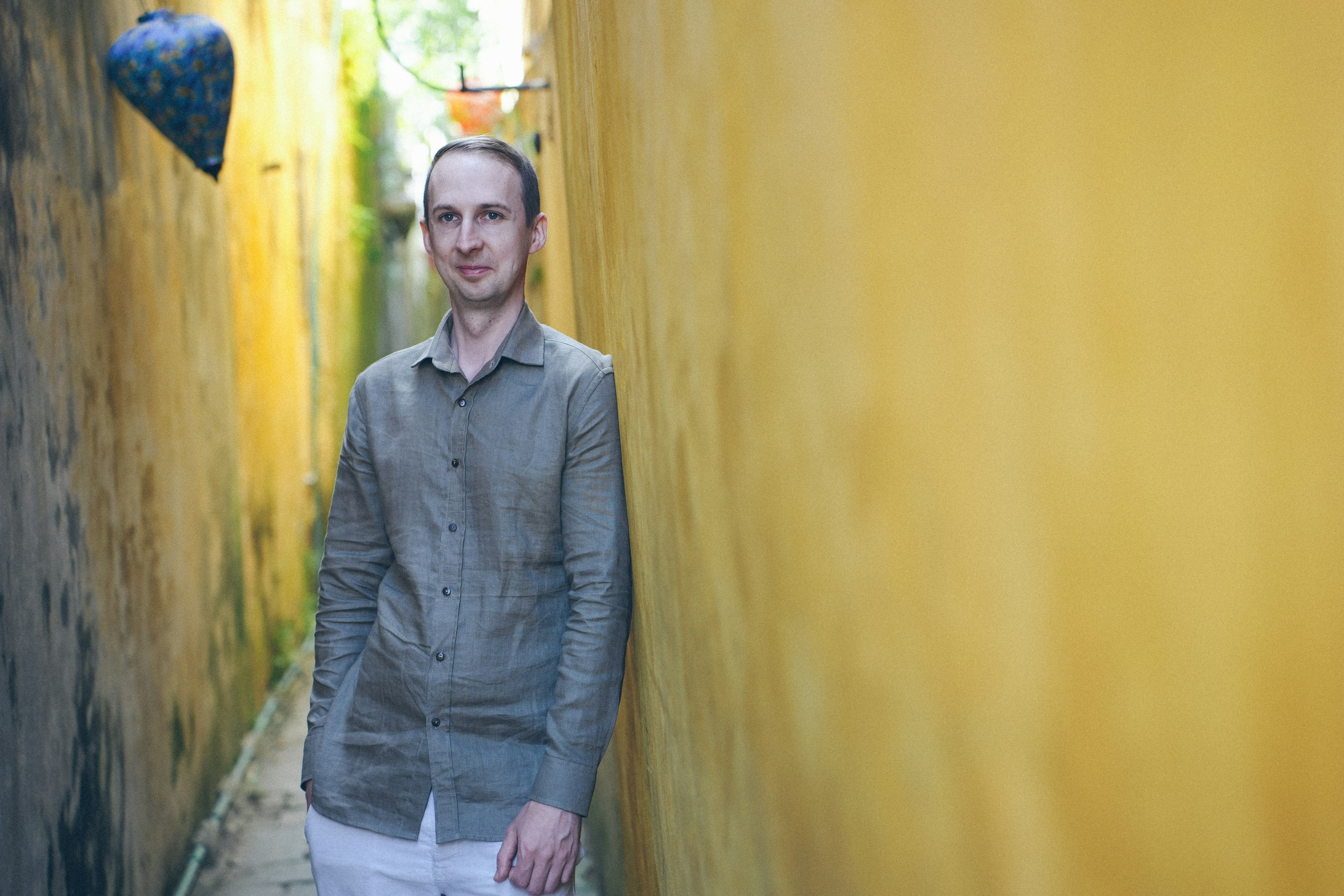 Portrait in a Sunlit Alley: Quiet Confidence Between Yellow Walls