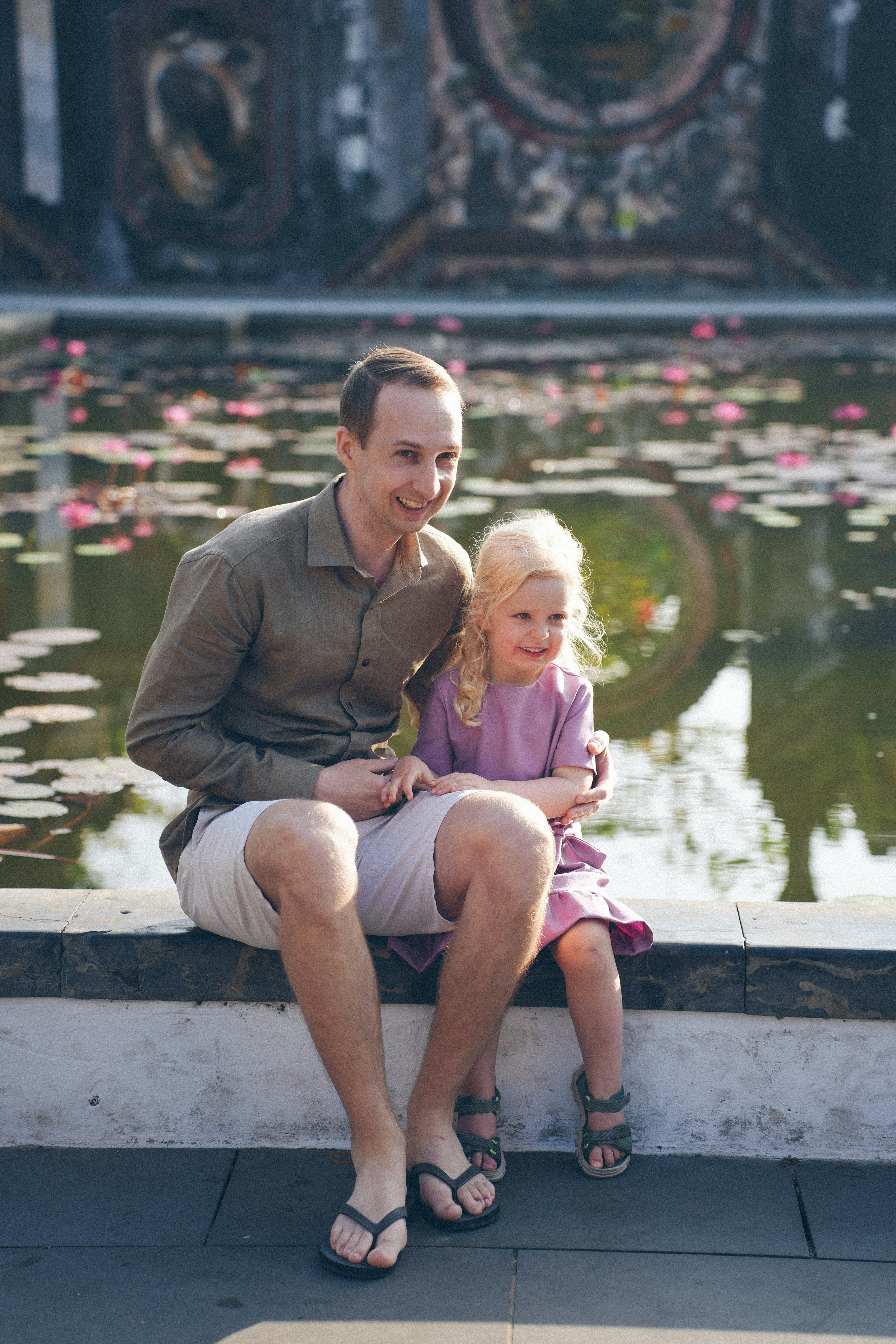 A Quiet Moment by the Water: Father and Daughter on the Terrace