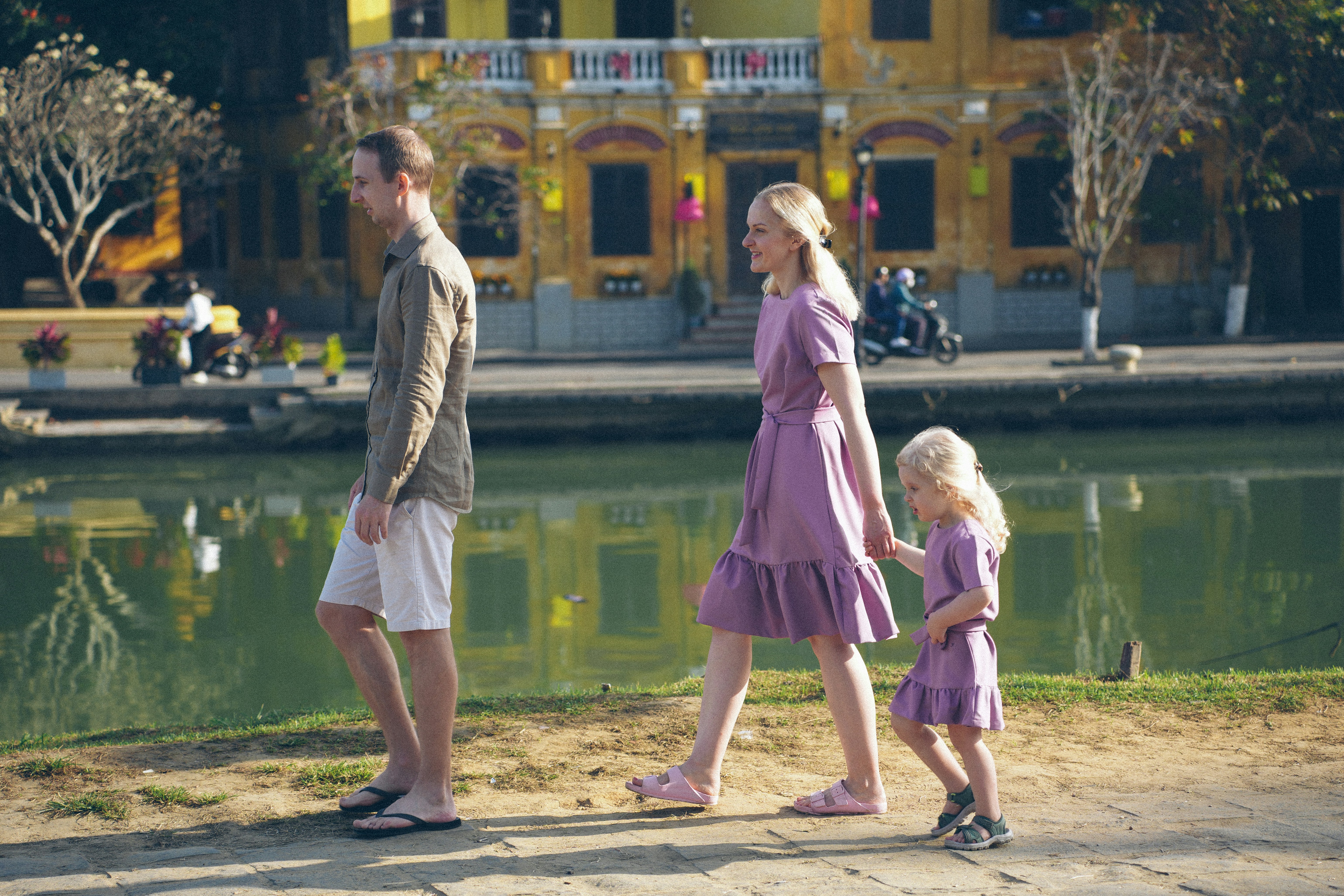 A family stroll along a sunlit lakeside path