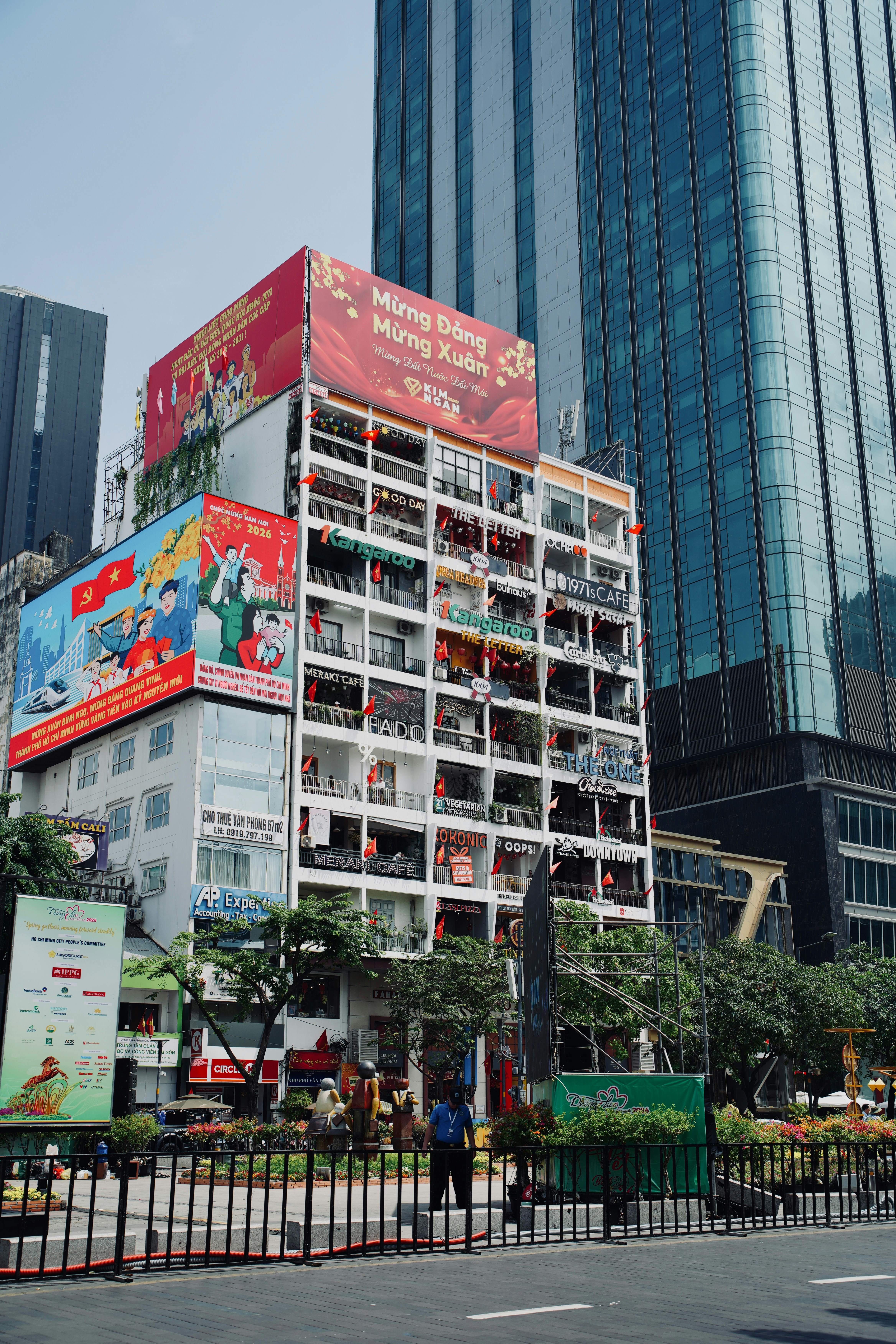 Colorful Midtown Façade: A Row of Signage and Street Activity Against Modern Skyscrapers