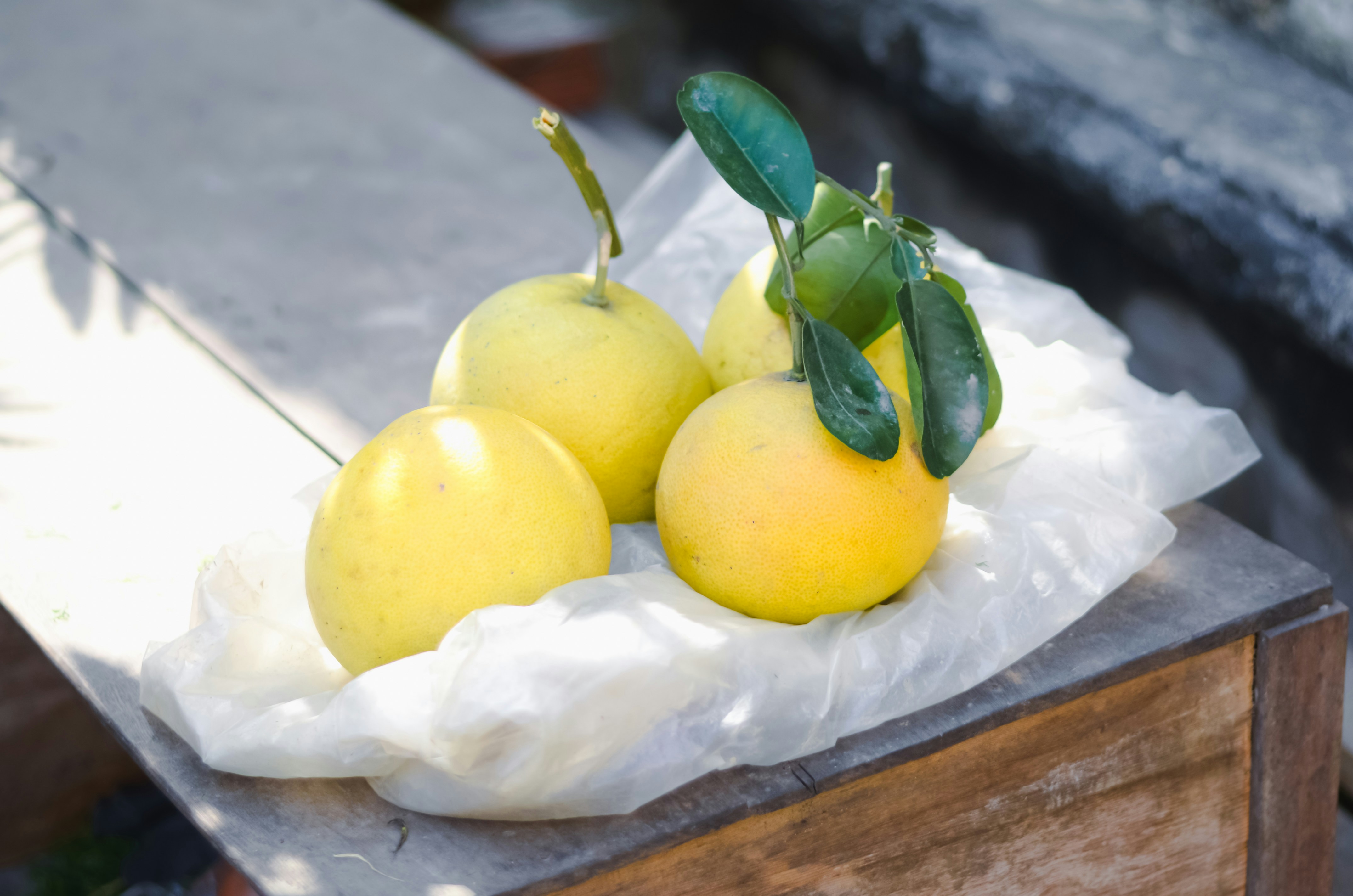 Citrus on White Silk: Fresh Lemons Resting on a Wooden Crate