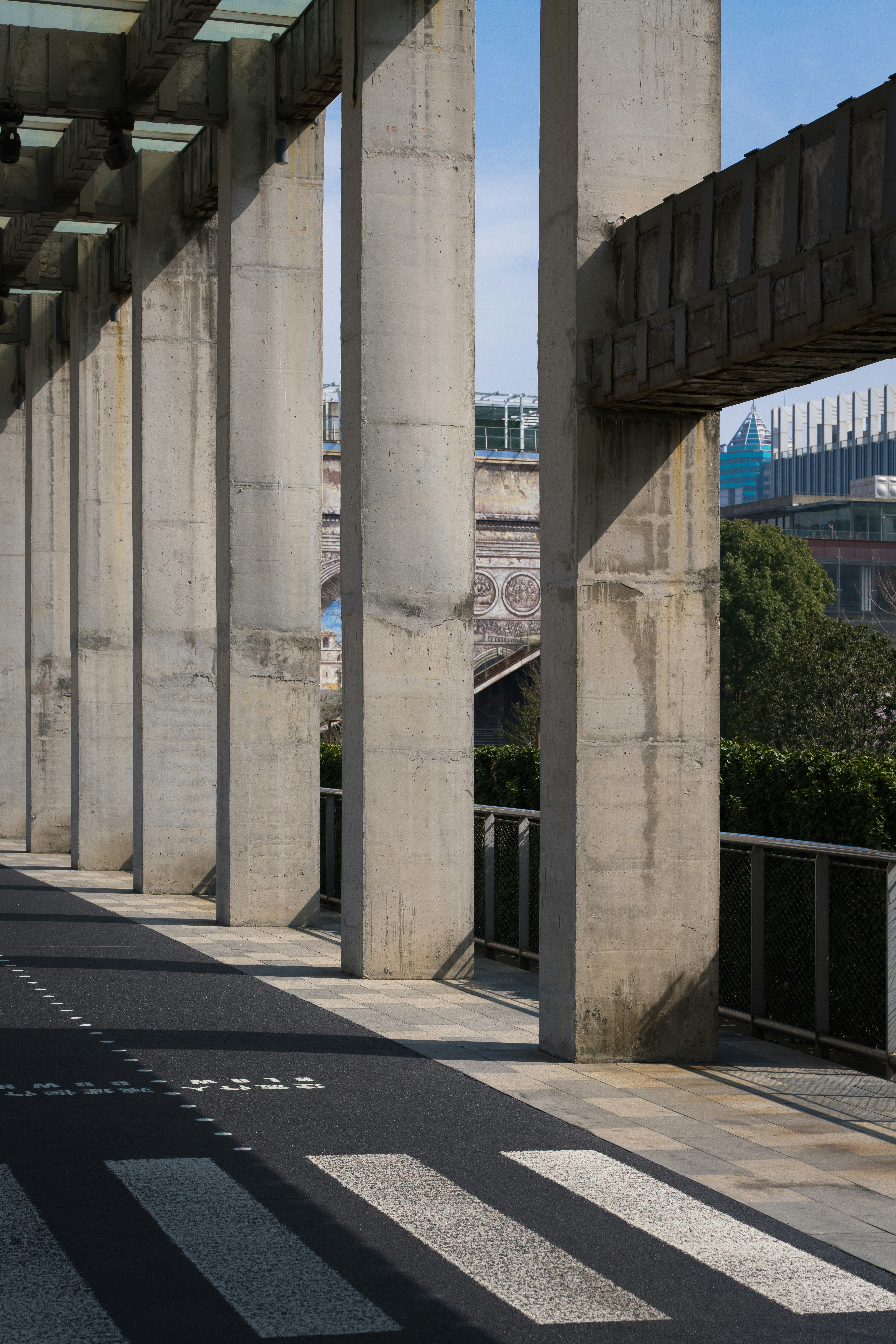 Columns and Shadowed Path Under a Concrete Bridge