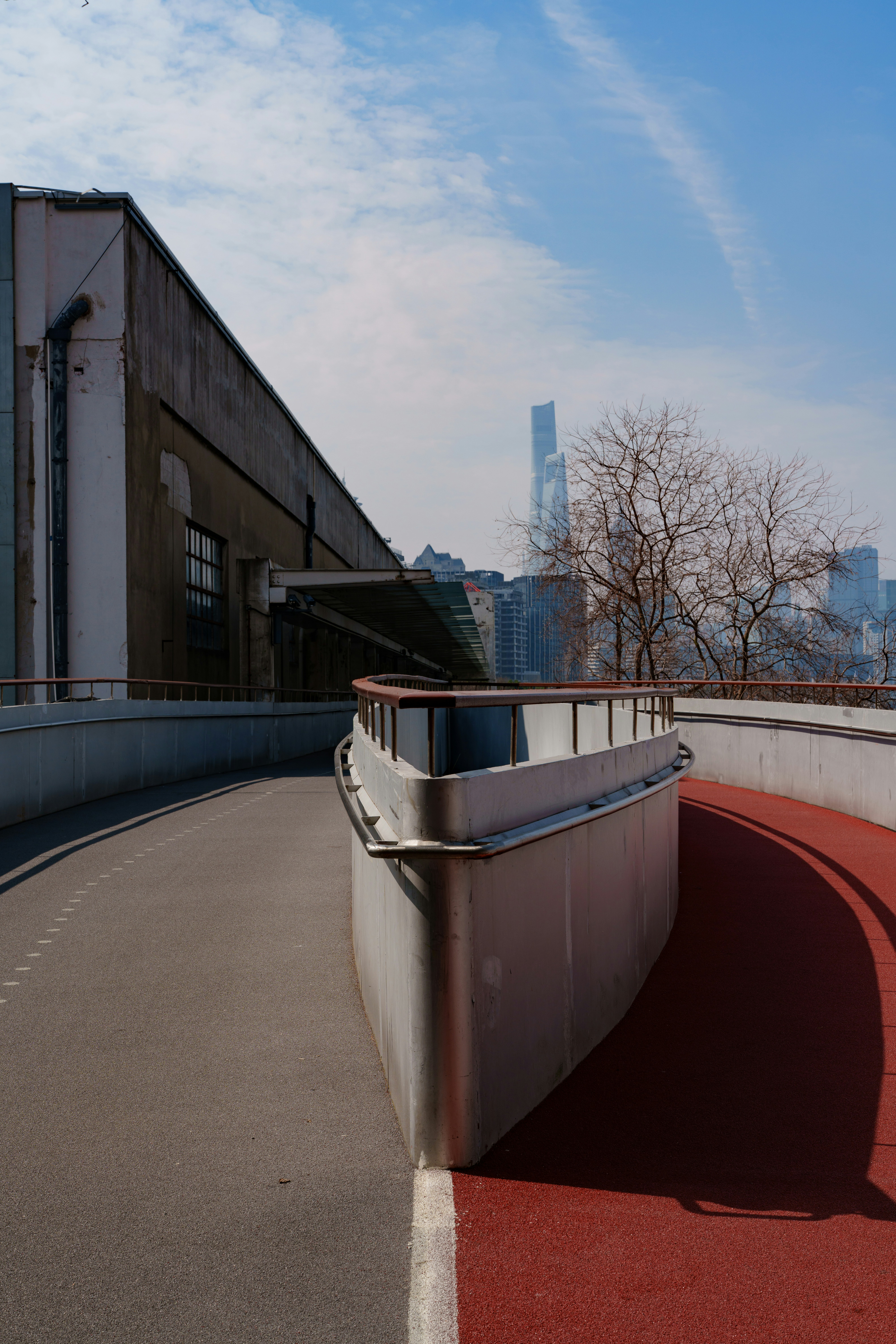 Curved Riverside Walk Piercing the City Silhouette