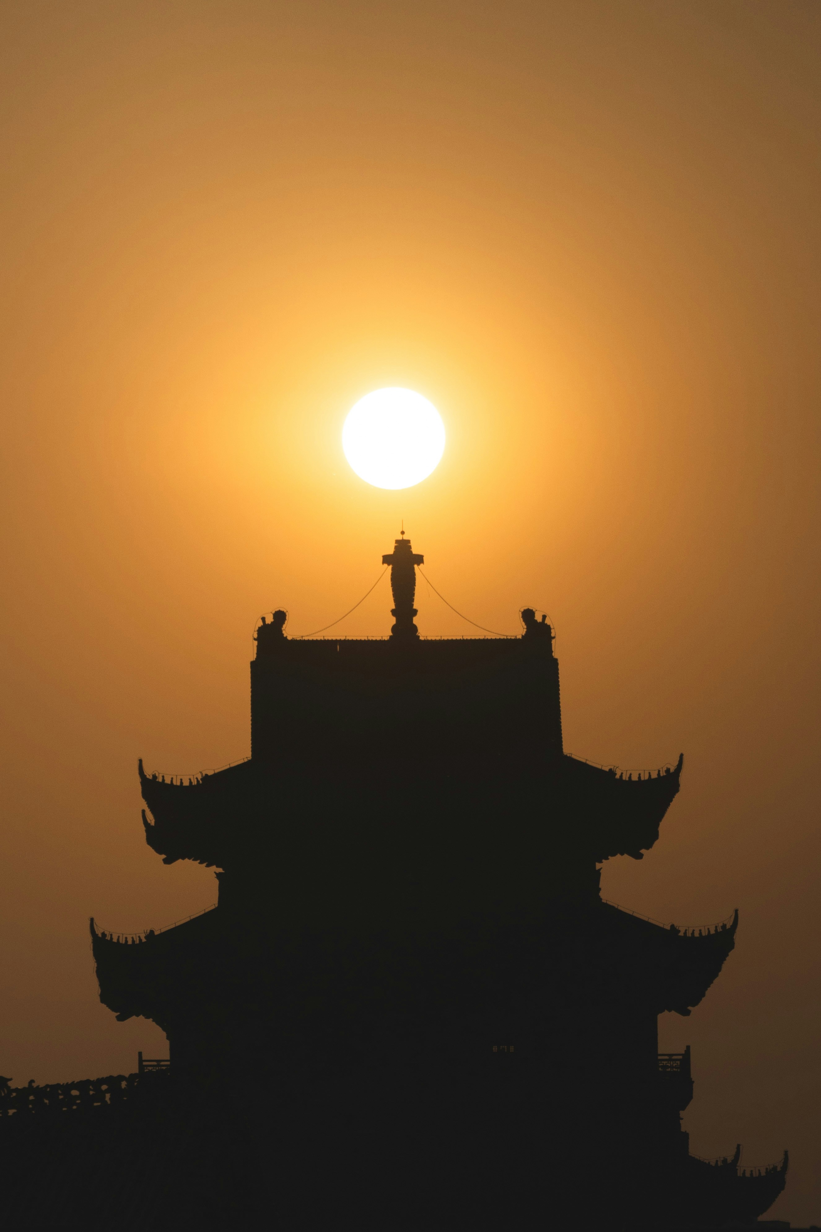 Sun-Kissed Pagoda: A Silhouette Beneath the Golden Orbs