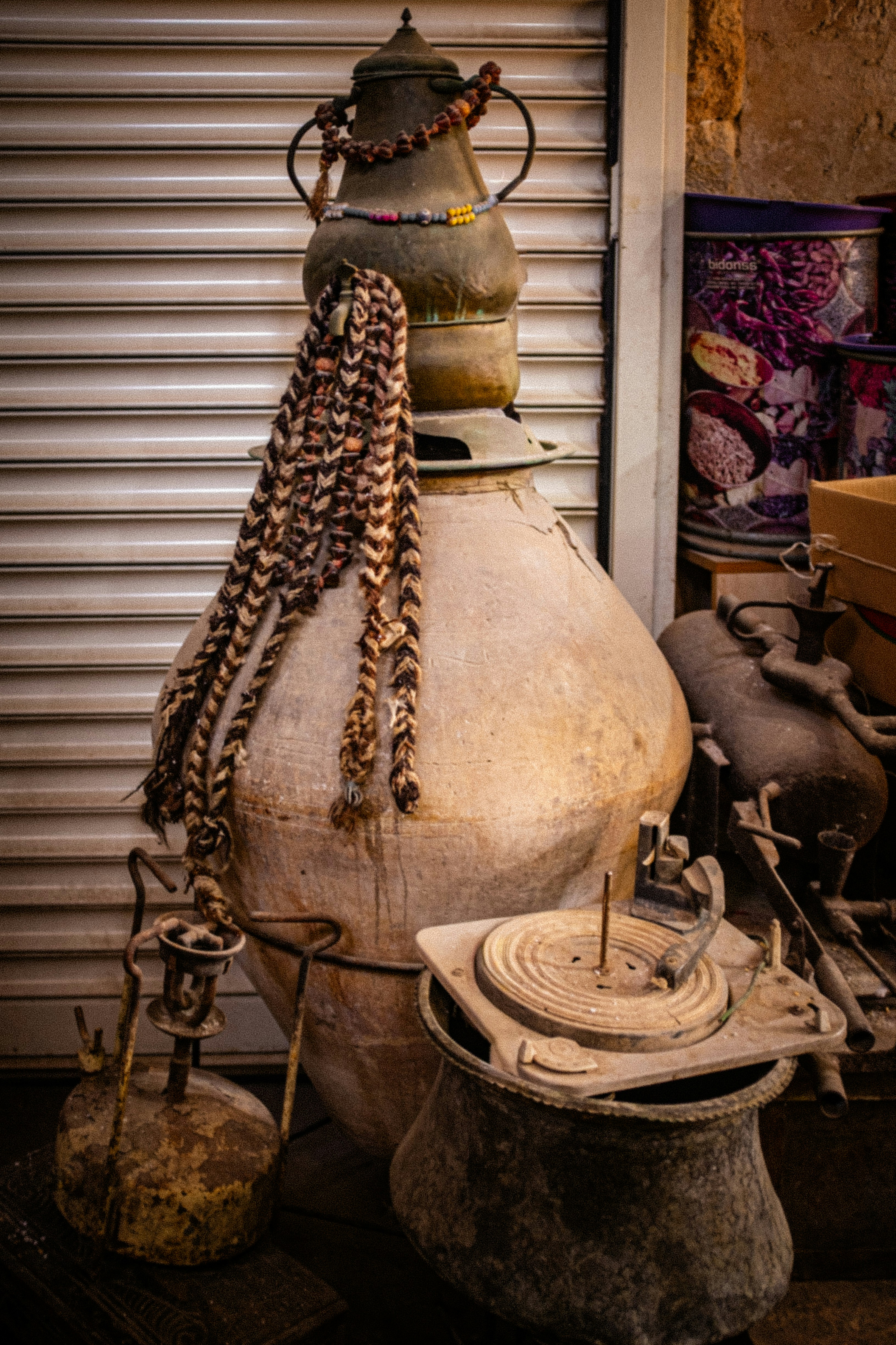 Dusty Still-Life: Old Distillery Gear by a Rolled Metal Door