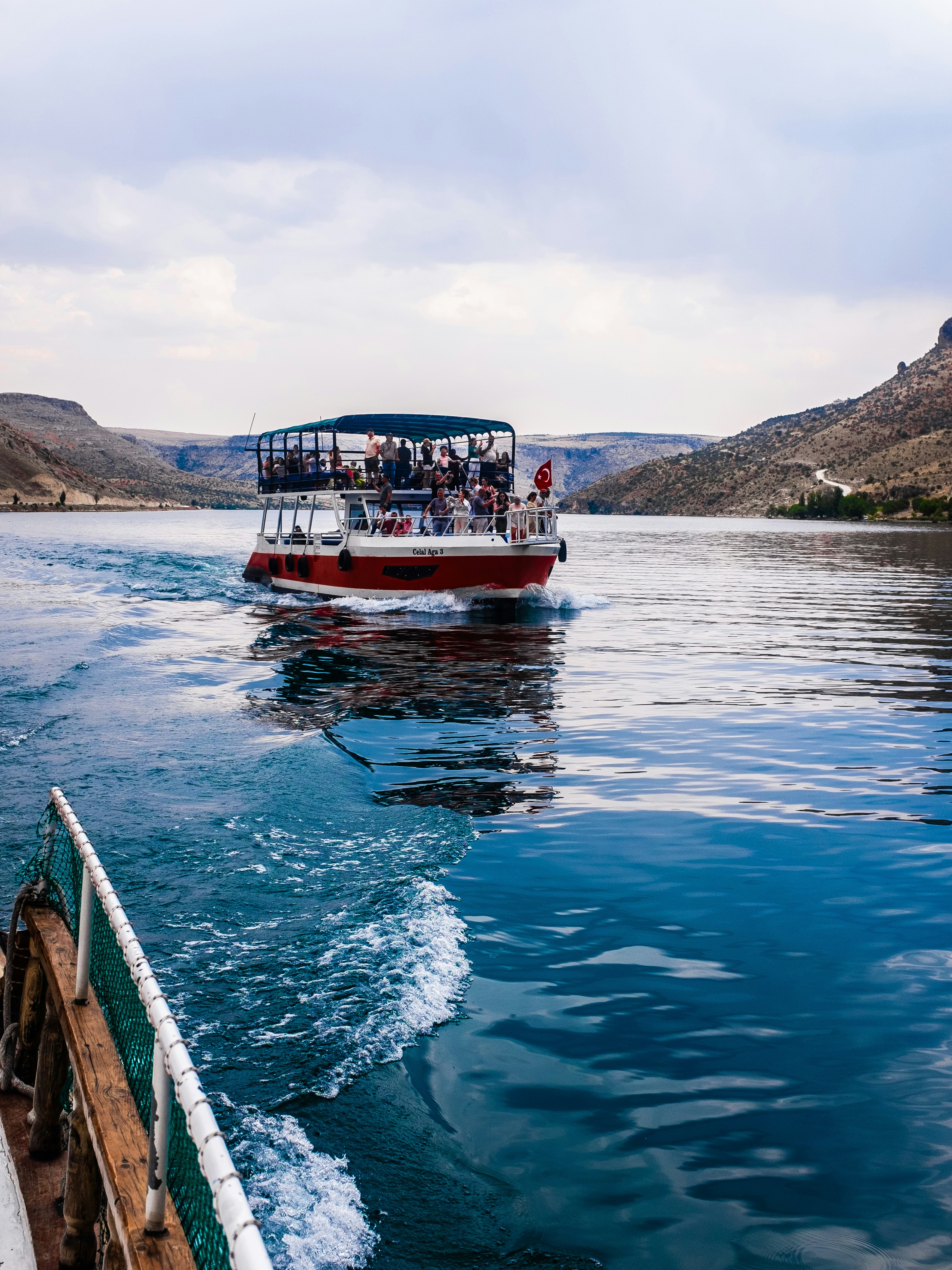 Red-Fronted Vessel and Canyon Backdrop: A River Passage