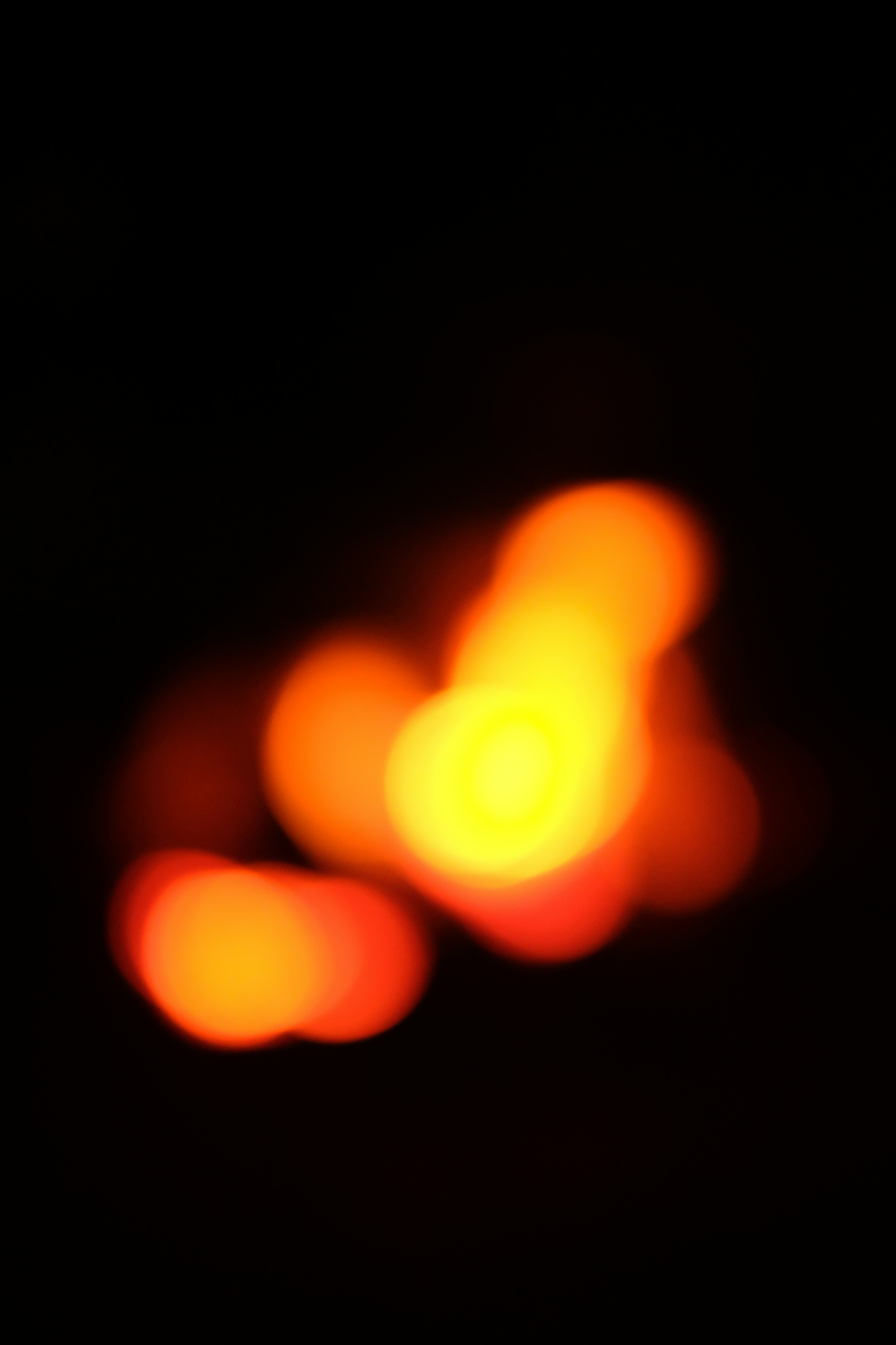 Soft Ember Blur: A Cluster of Orange Lights in Darkness