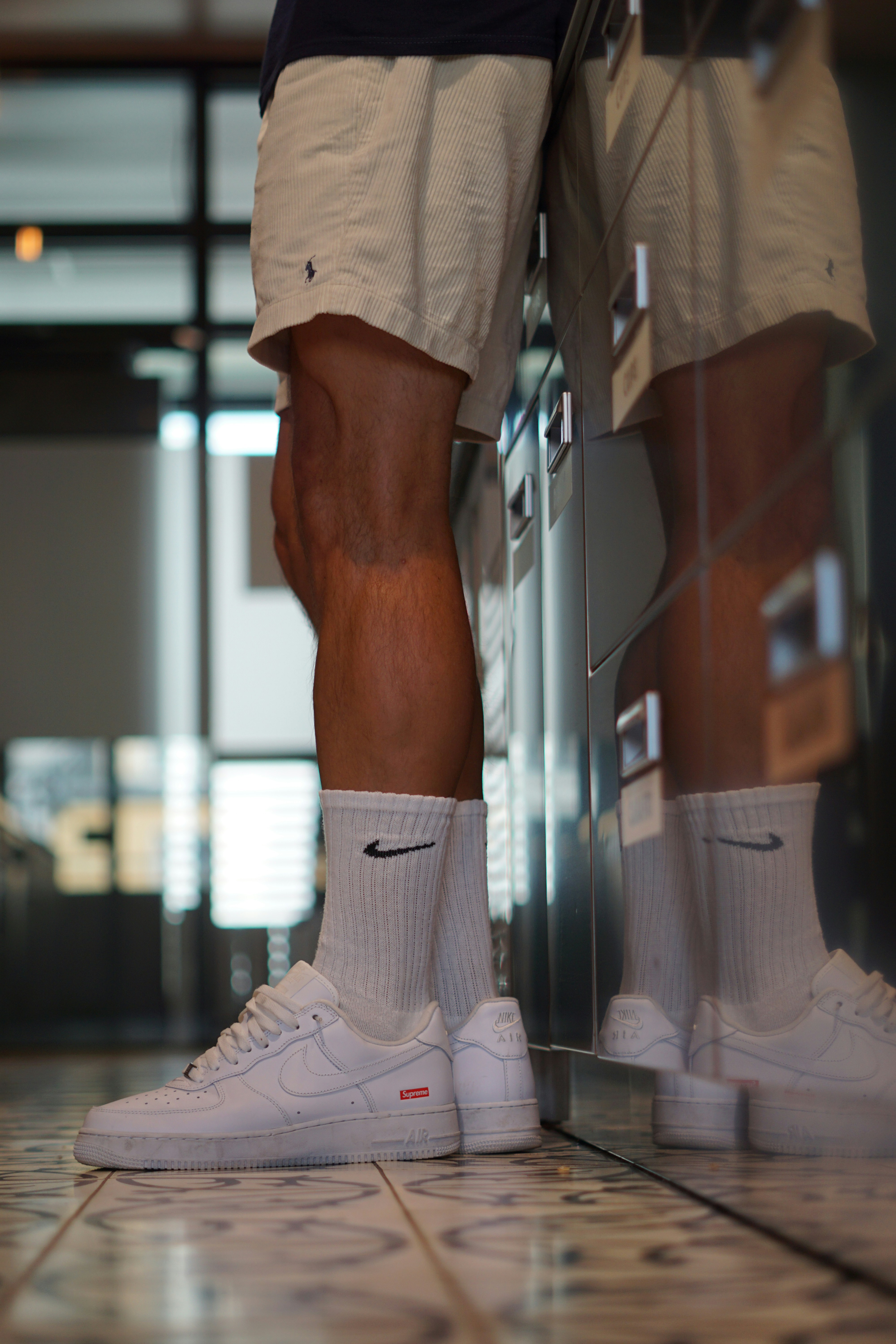 Mirror Steps: A Runner's Reflection in White on a Tiled Floor