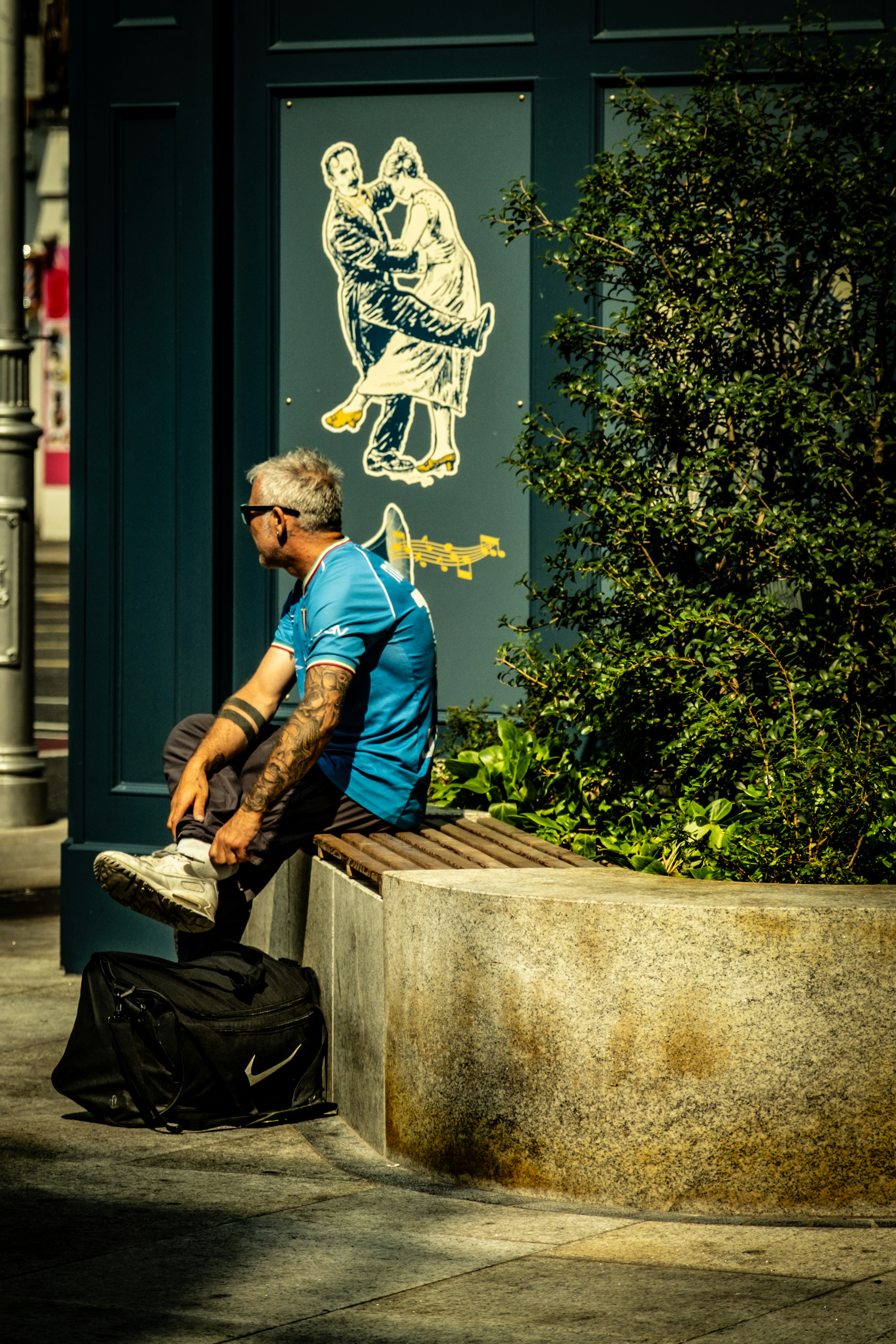 Blue-Striped Moment: A Contemplative Seat Amid Urban Greenery