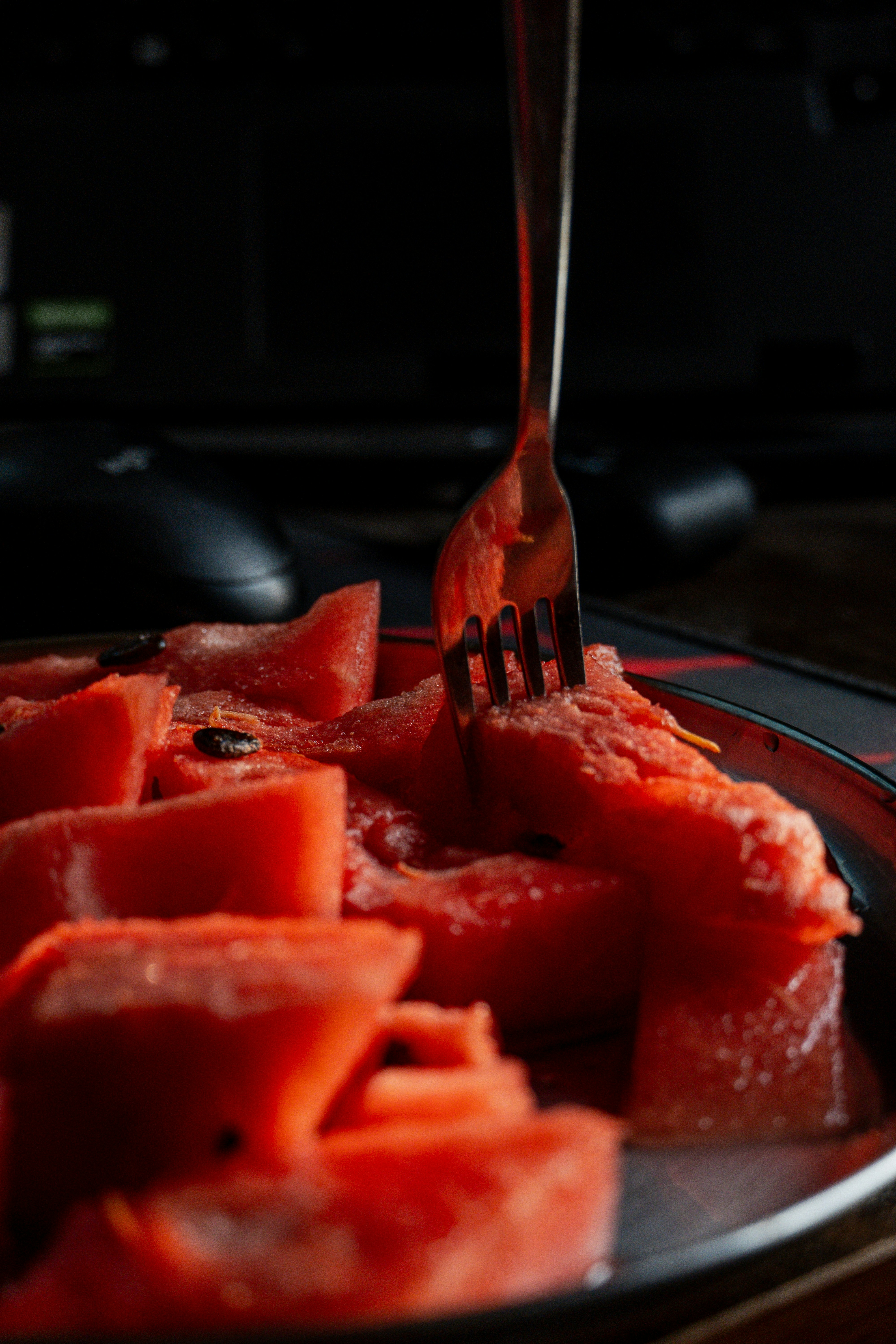 Juicy Red Moment: Fork Touched Watermelon in Low Light