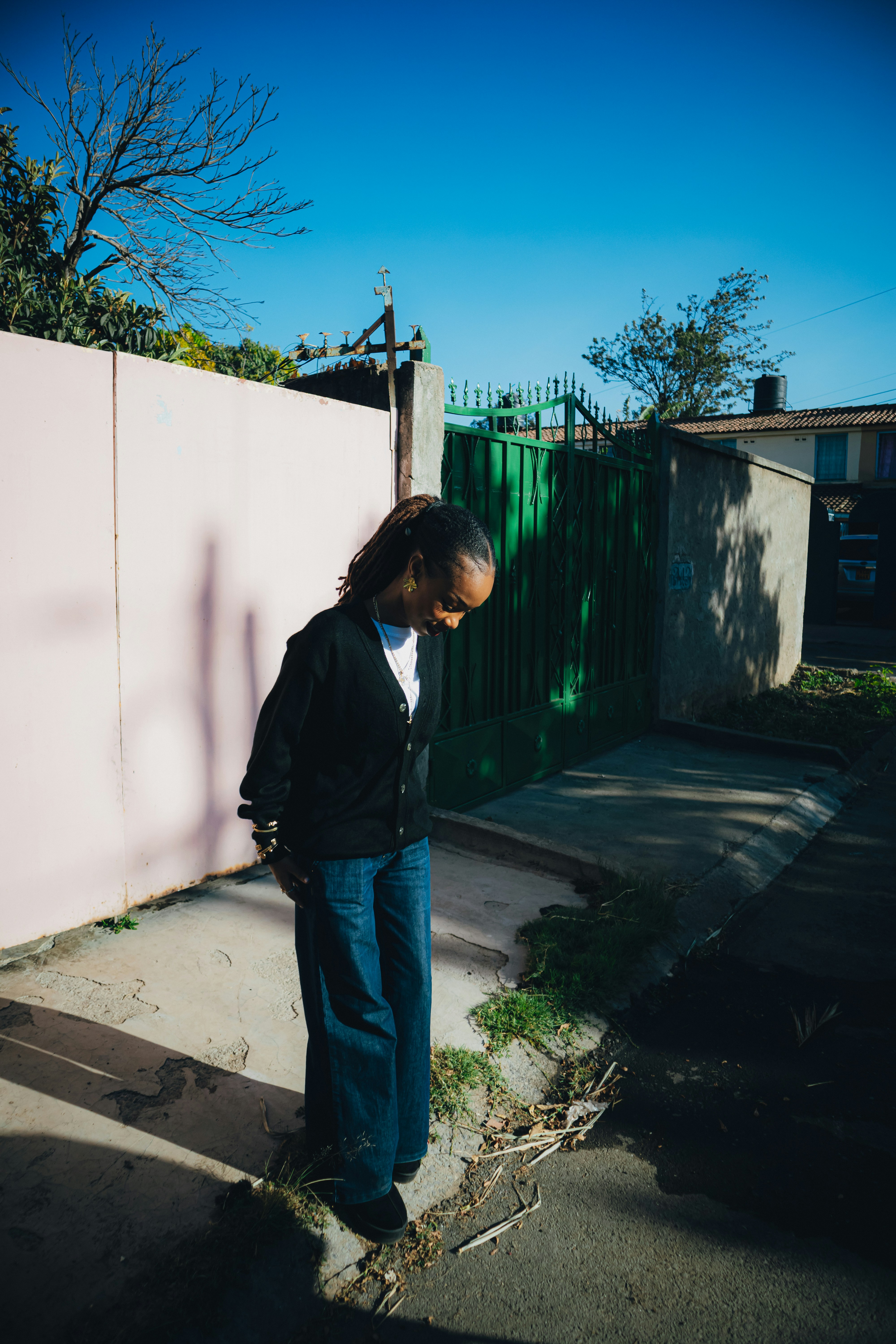 Edge of Shore: A Woman in Shadowed Light on a Quiet Street