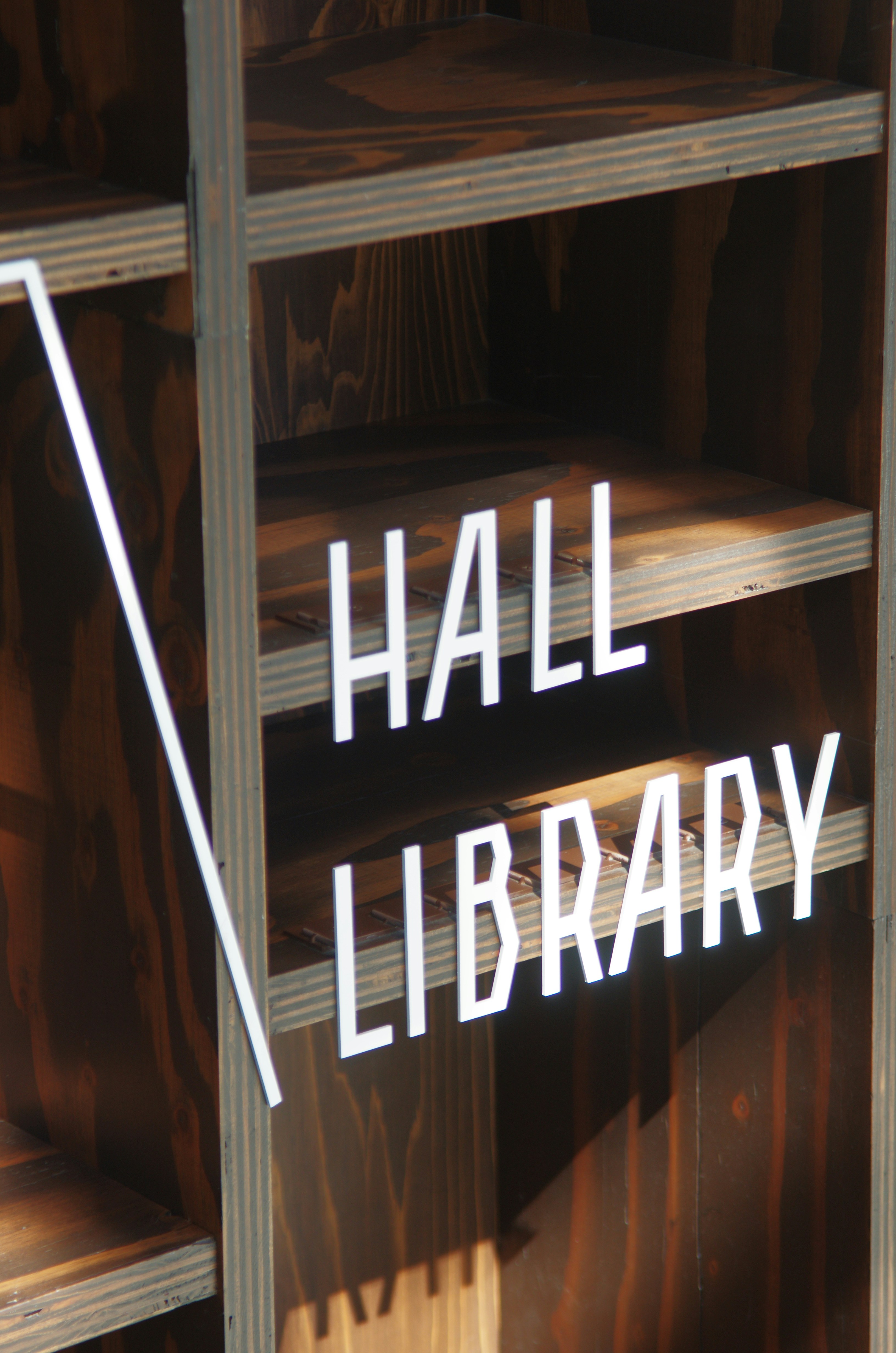 Illuminated Halts: Signage on a Wooden Library Shelf
