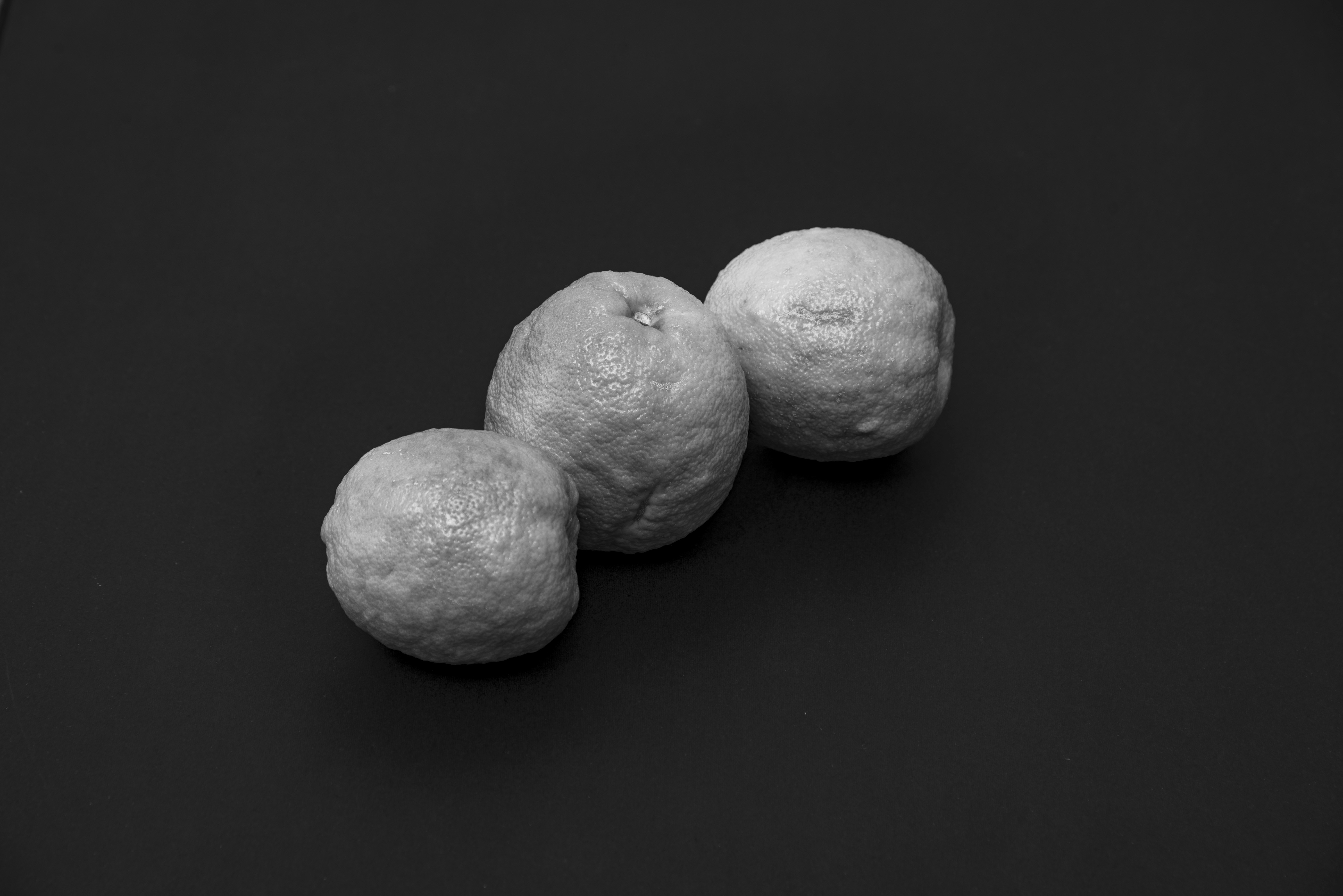 Three Citrus Orbs in Quiet Studio