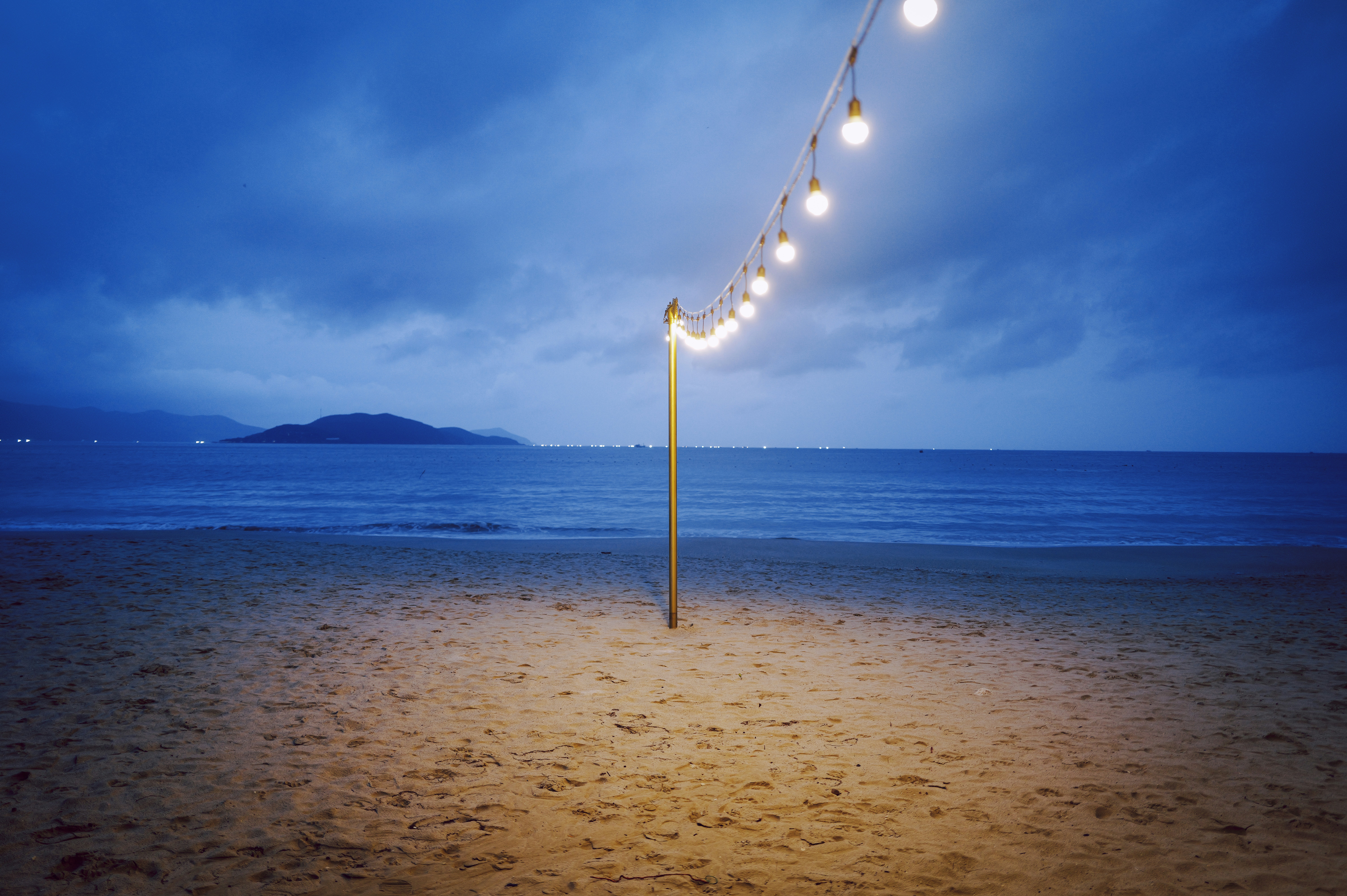 String of Lights Over Quiet Shore: Evening Lounging on the Sand