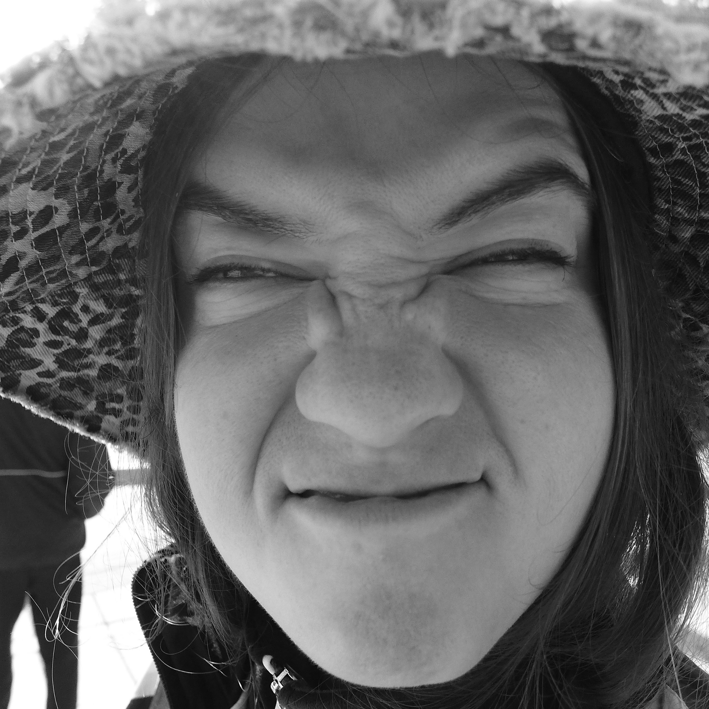 A person makes a funny face while wearing a hat.