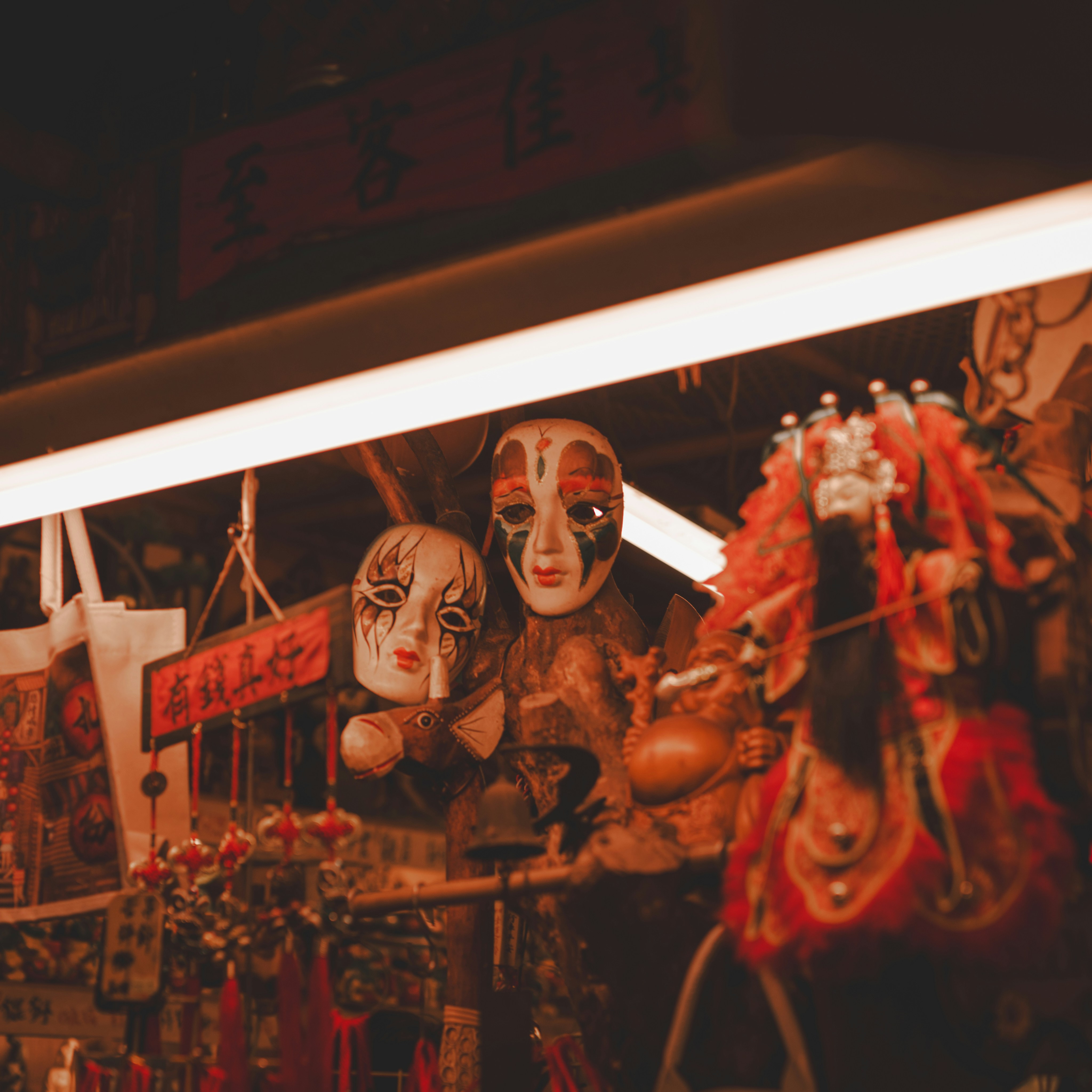 Masks Under Neon Glow in a Night Market Stall