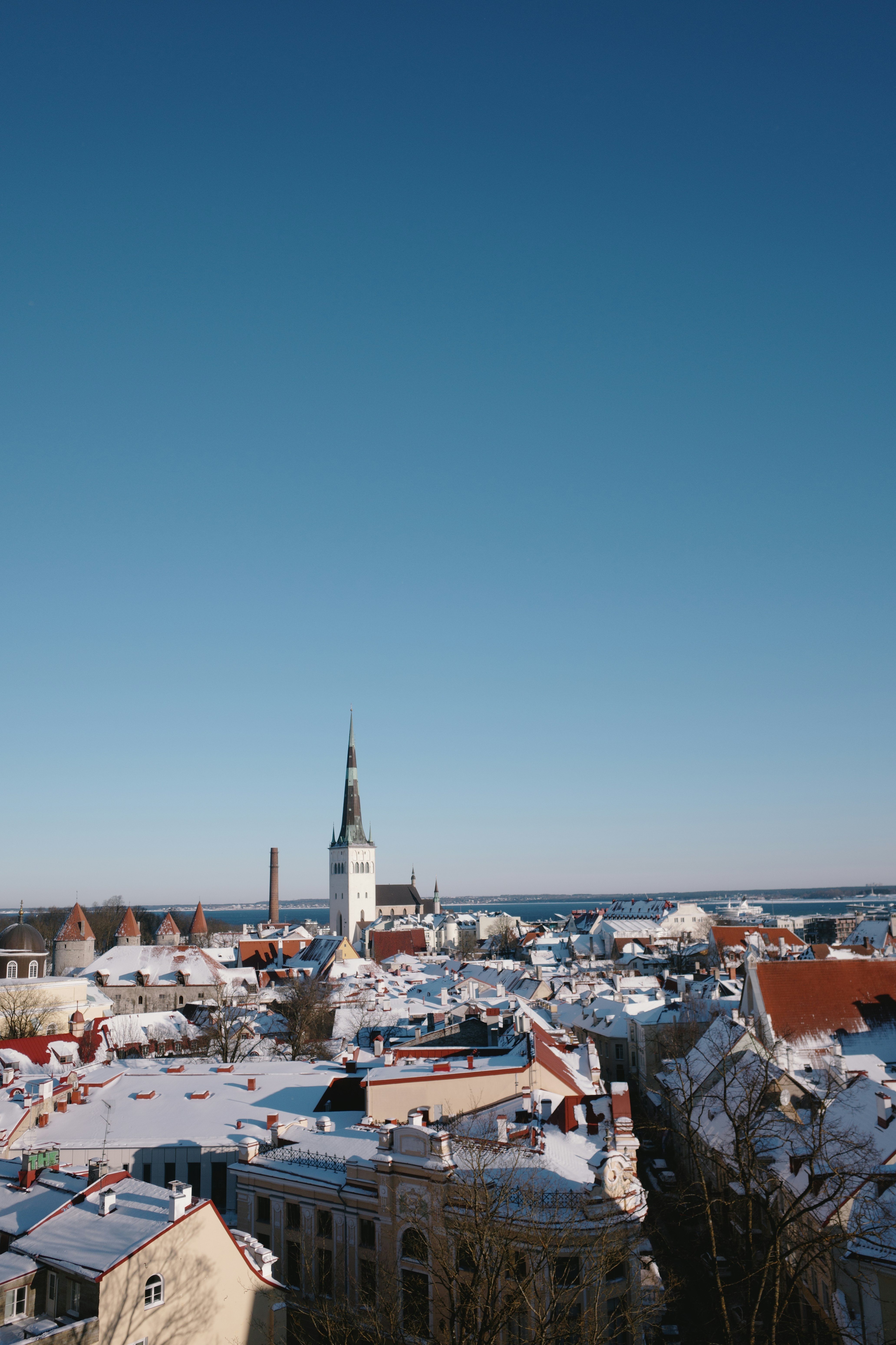 Snow-covered rooftops in a historic city under clear sky