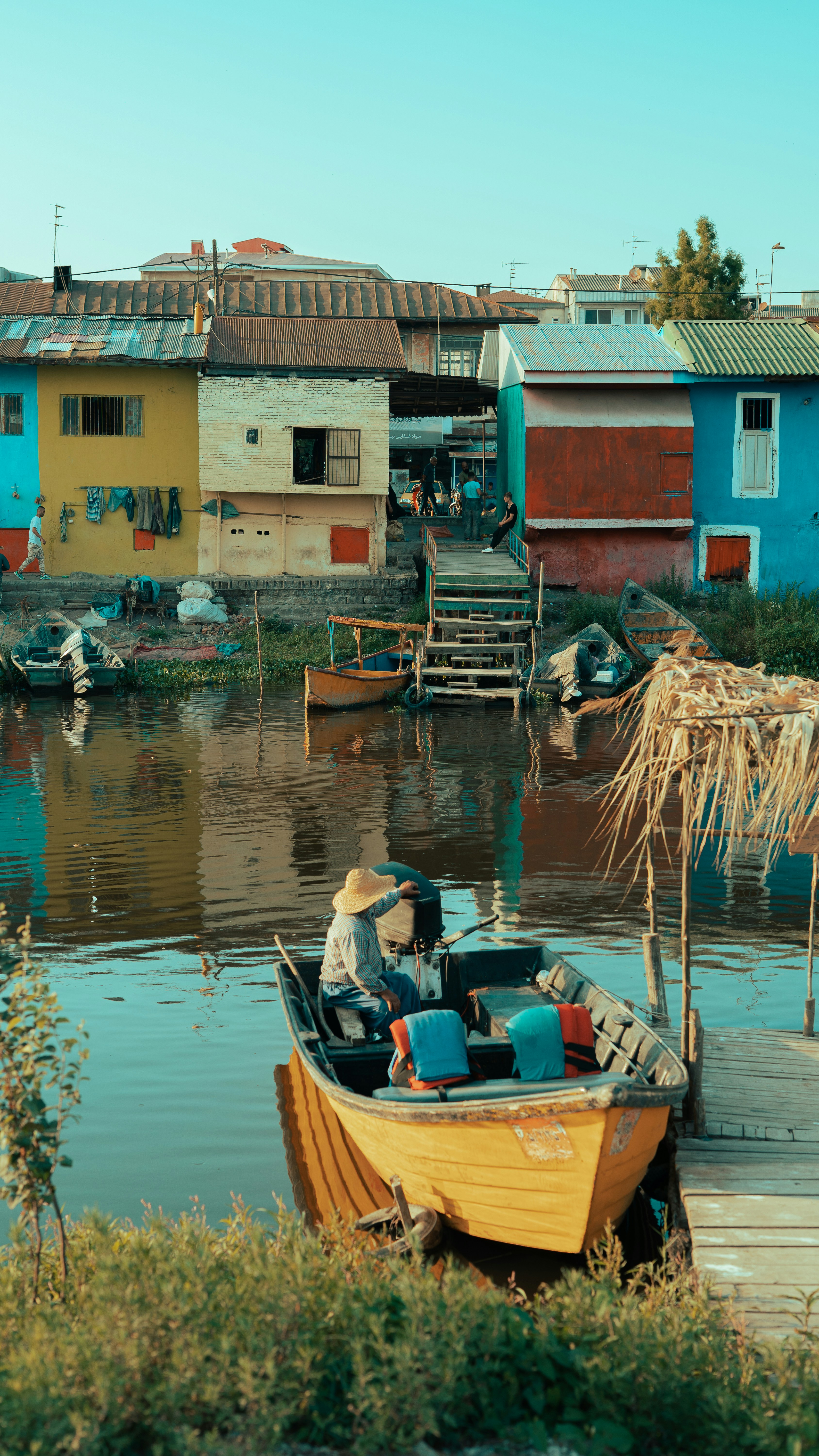 Colorful Canal Village: A Weathered Boat at the Edge of Riverside Homes
