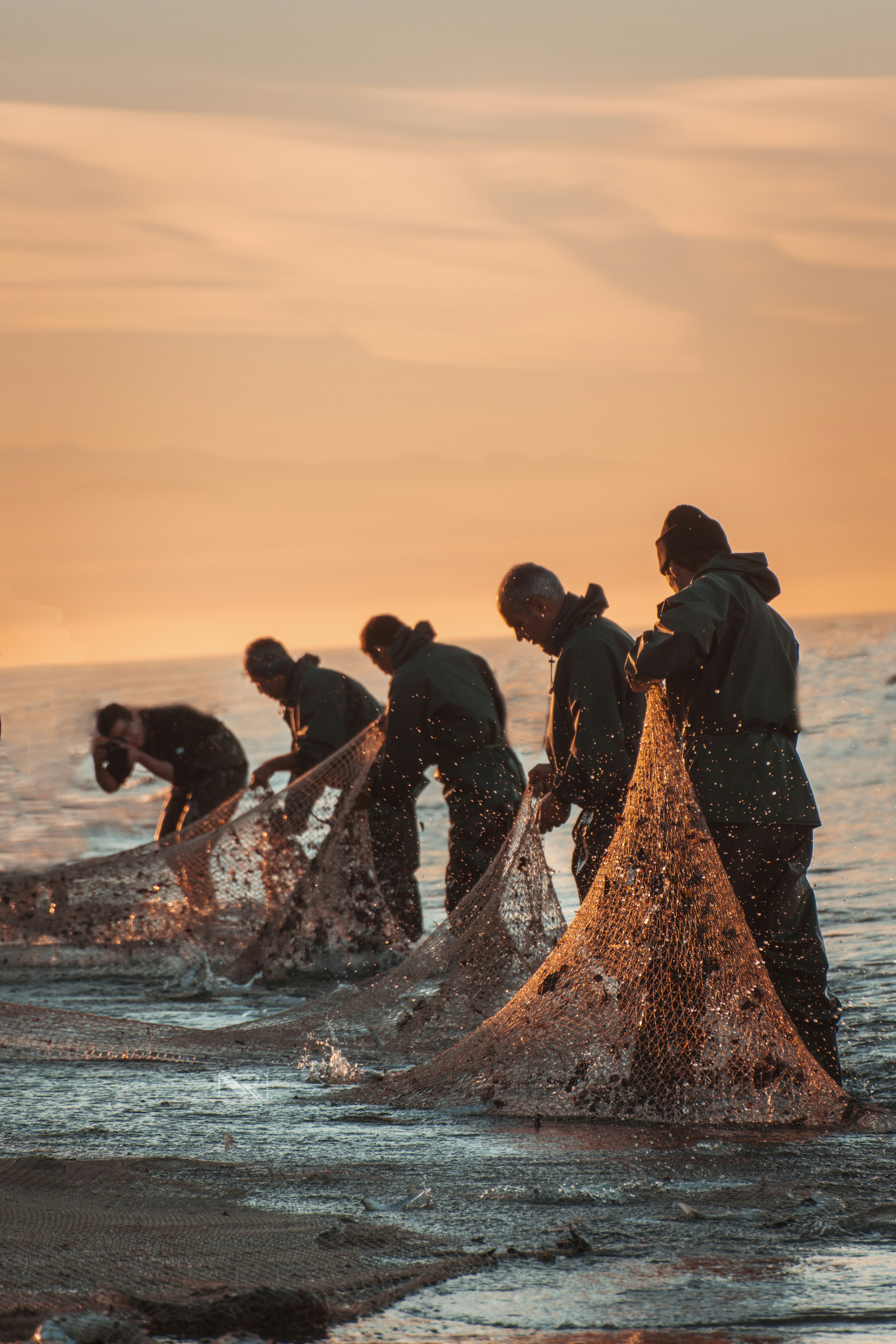 Netting the Sunset: Fishermen at Work on a Fiery Shore