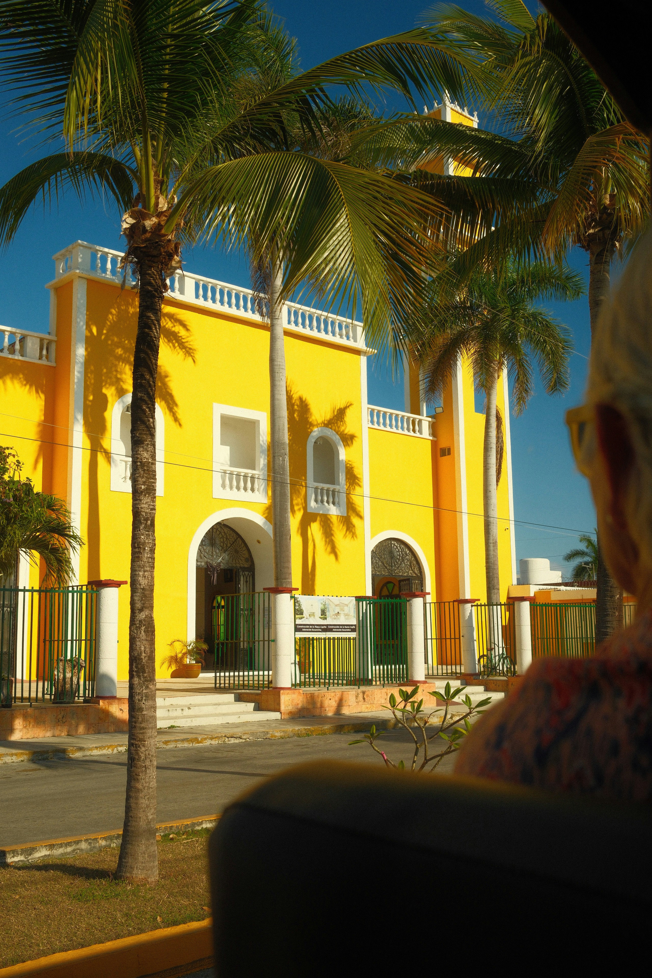 Sunlit Yellow Villa Framed by Palm Shadows