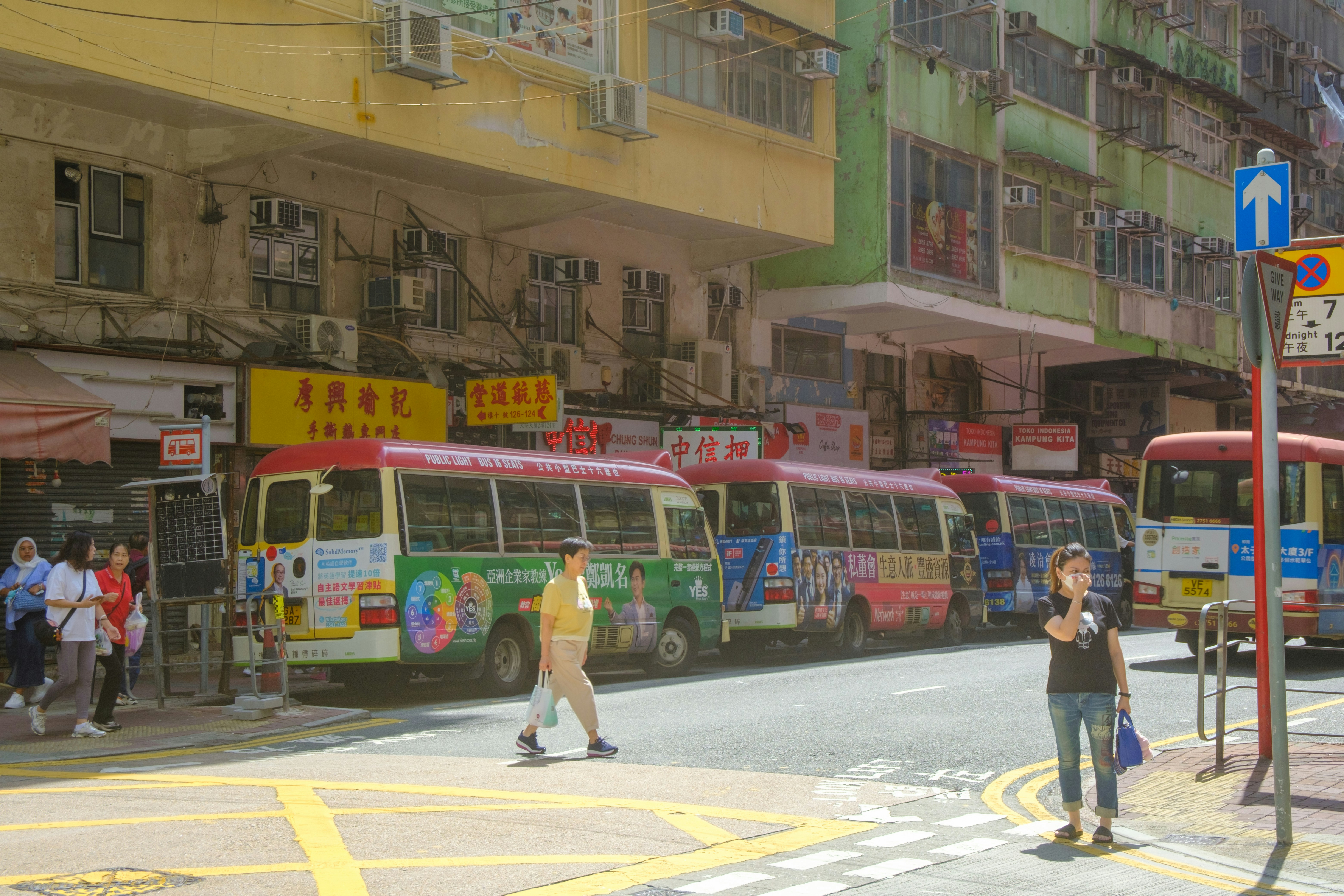City Street Pulse: Buses, Pedestrians, and Neon Signs