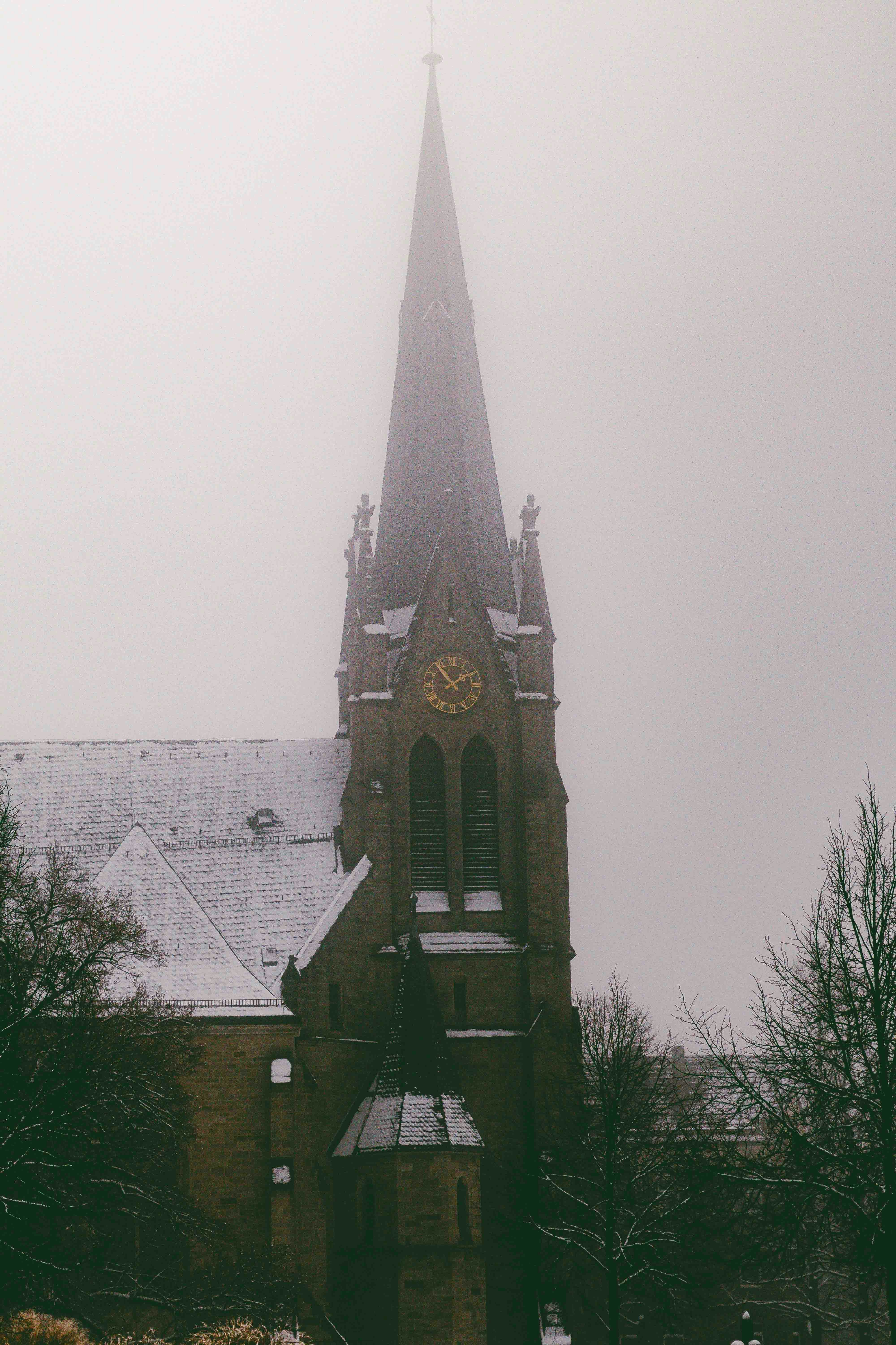 Snowbound Spire: A Church Tower Emerges through Hushed Winter Mist