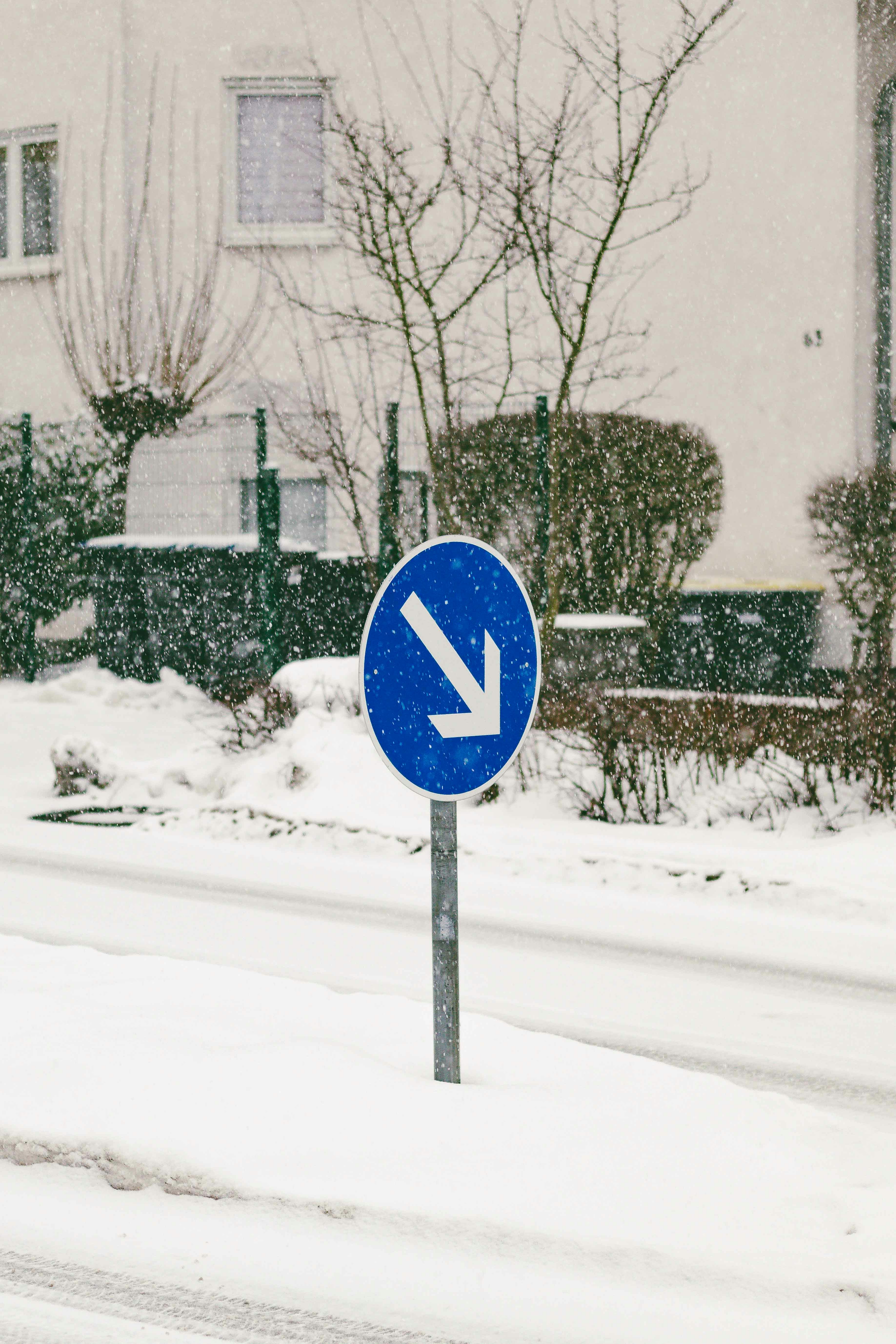 Snowy Street Sign with Downward Arrow: Guiding Through White Quiet