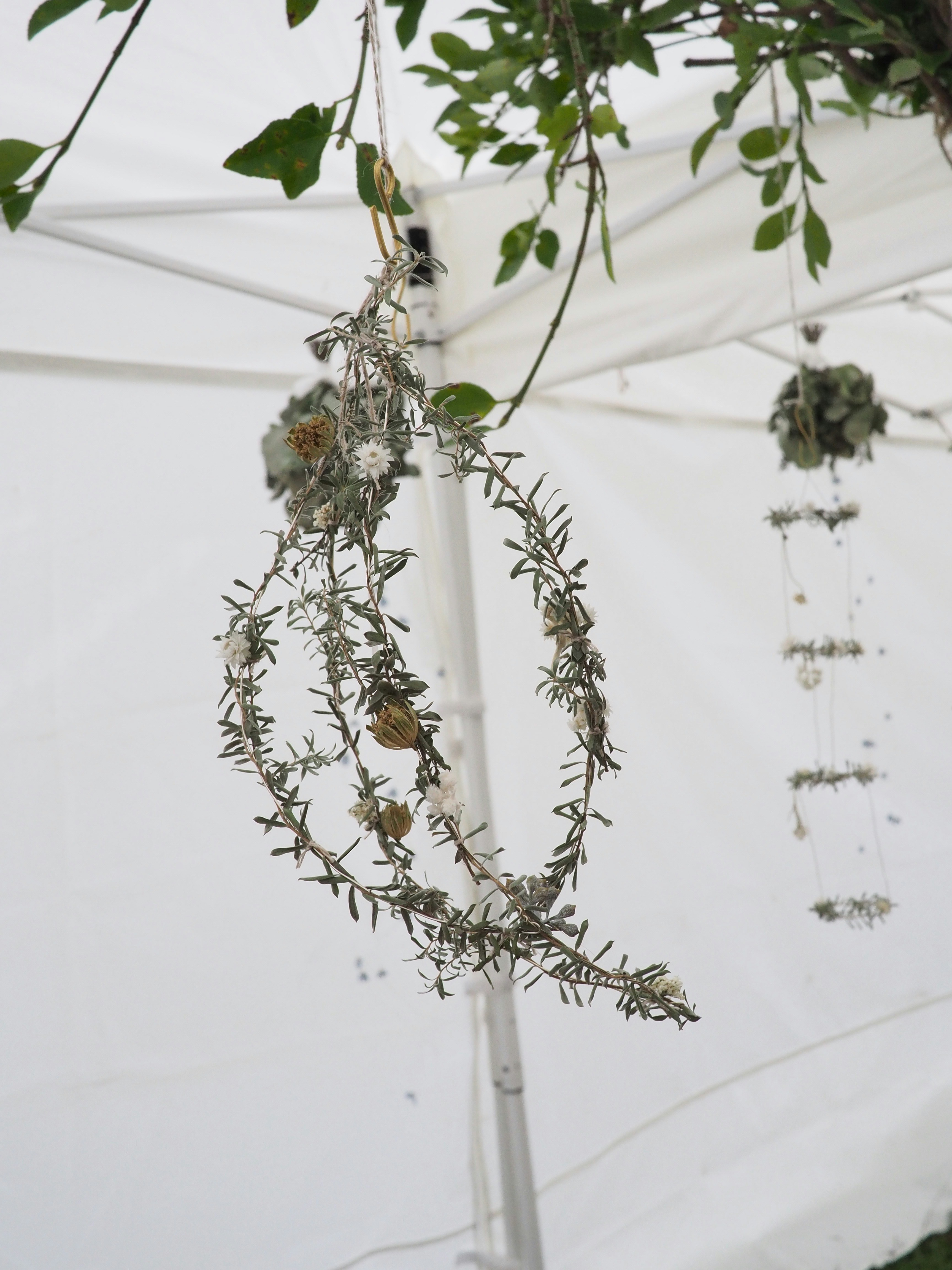 Hanging wreath frame of dried florals in a white tent